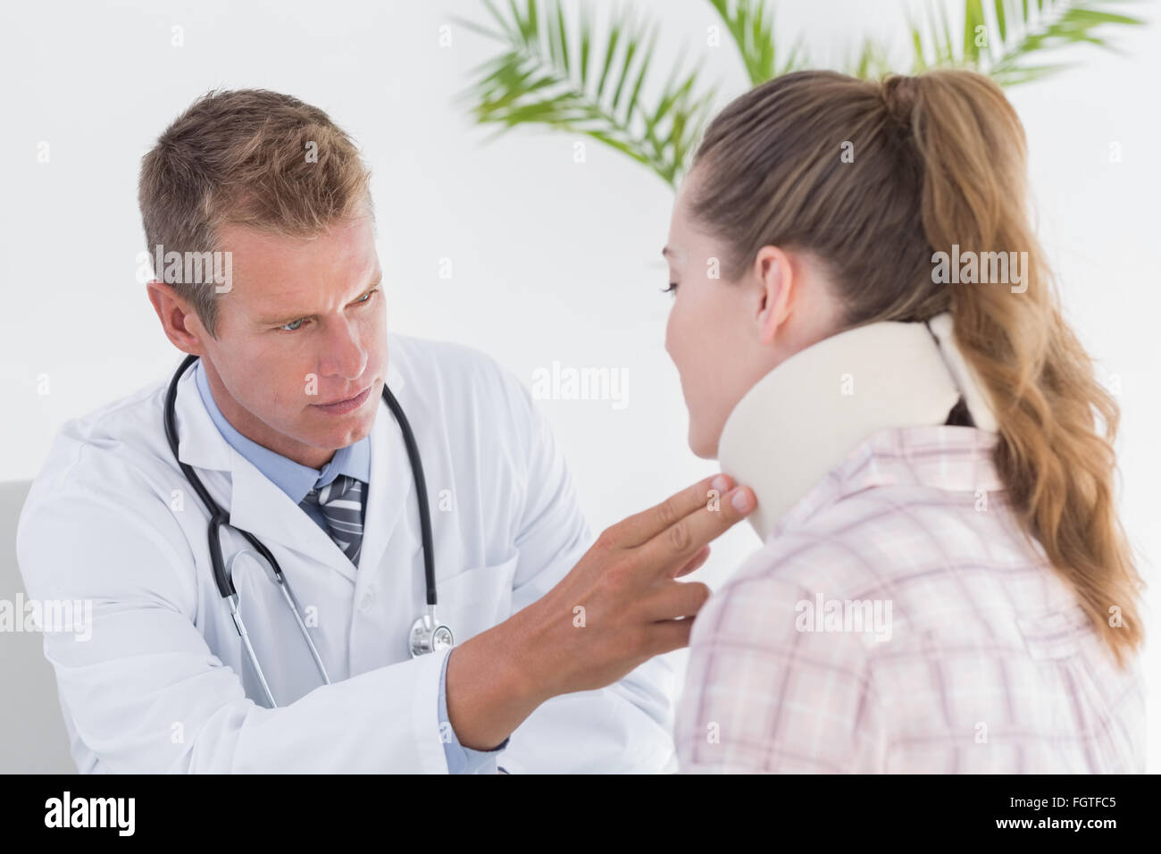 Doctor examining patient wearing neck brace Stock Photo - Alamy