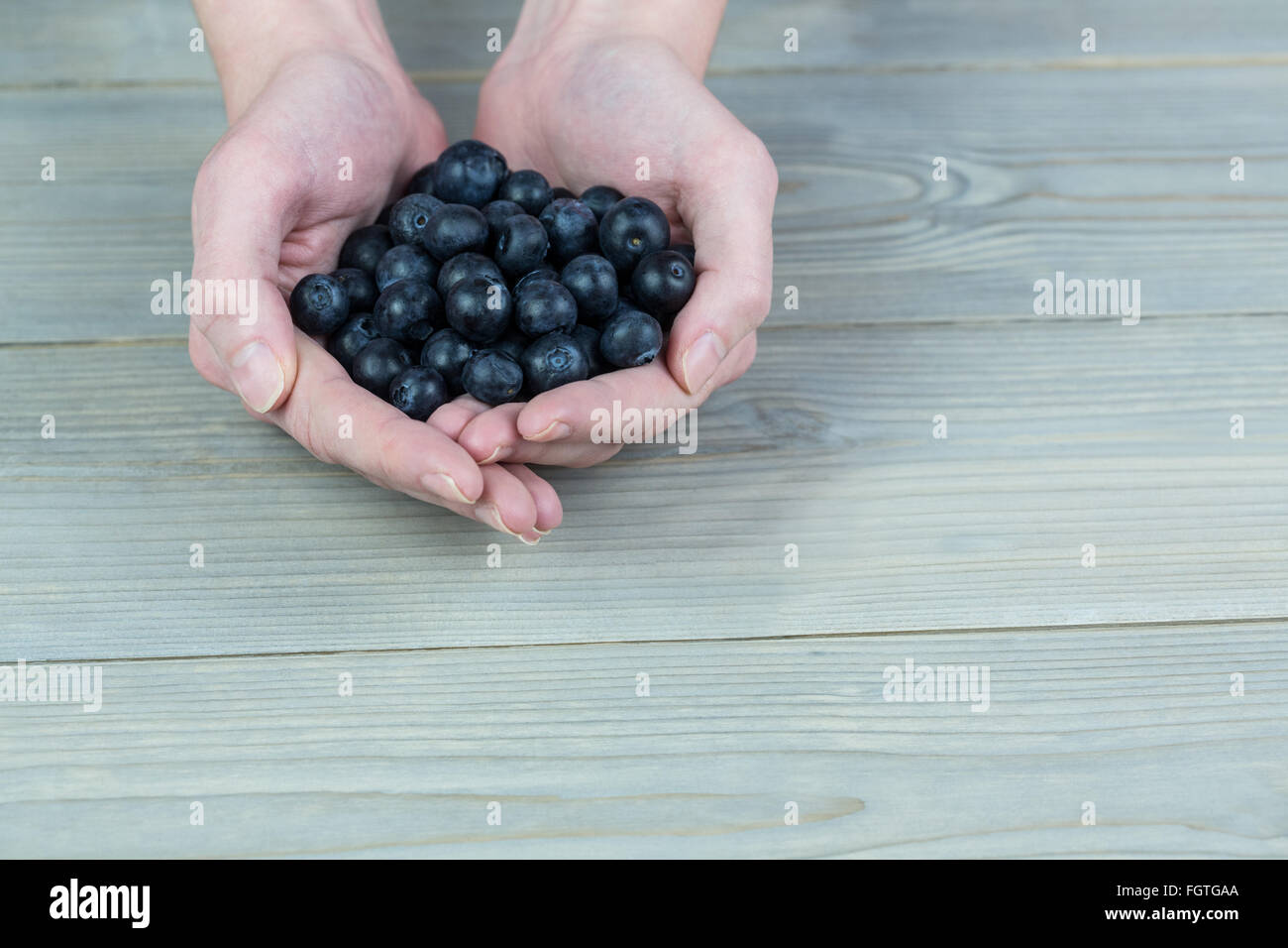Woman showing handful of blueberries Stock Photo - Alamy