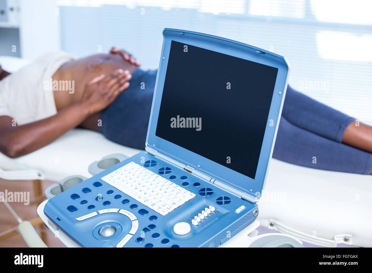 Ultrasound machine with pregnant woman lying in background Stock Photo ...