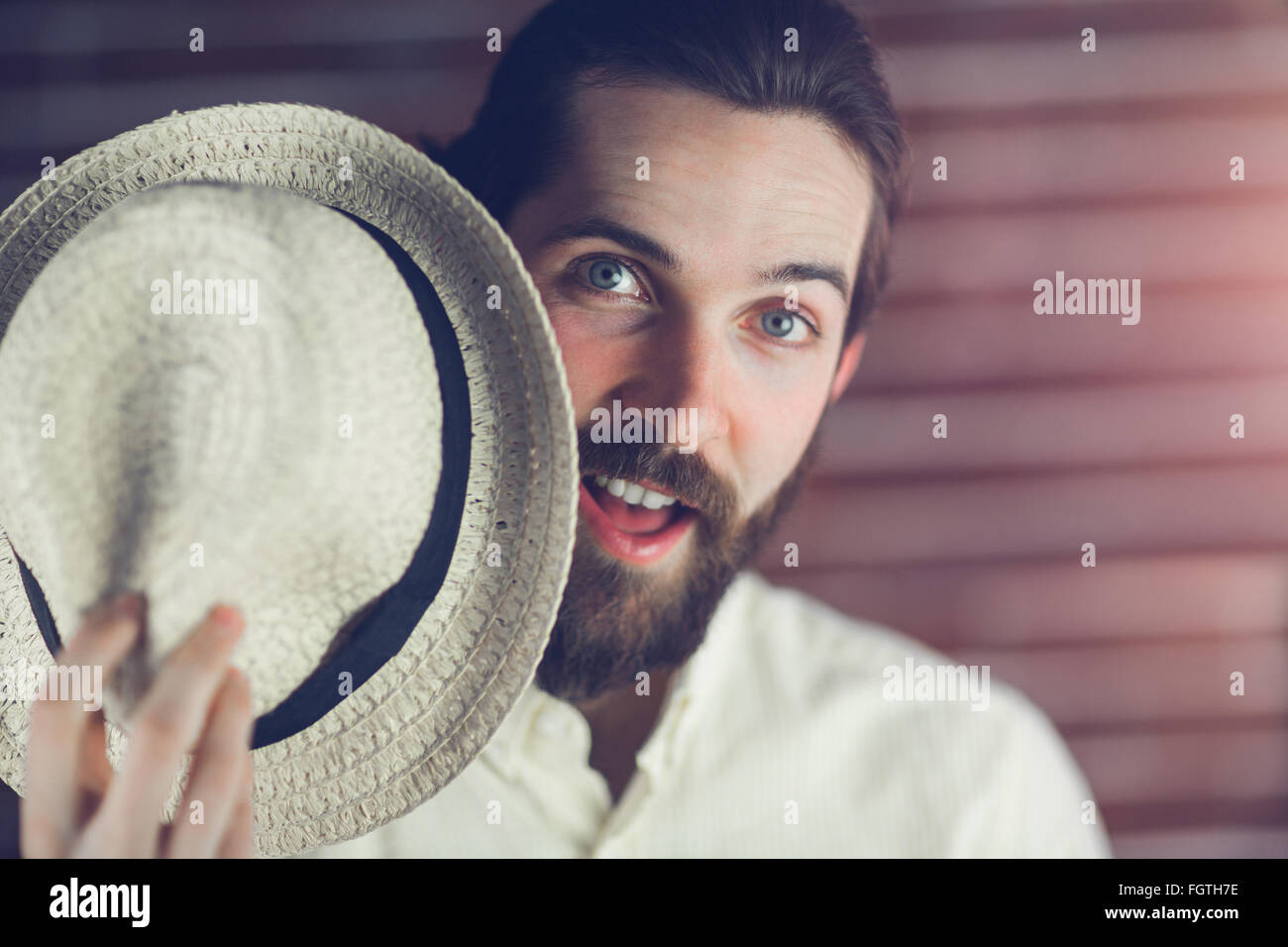 Surprised man holding hat Stock Photo - Alamy