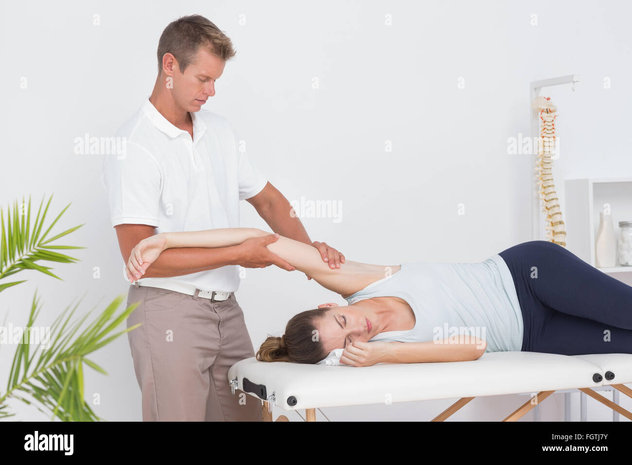 Doctor stretching his patient arm Stock Photo - Alamy