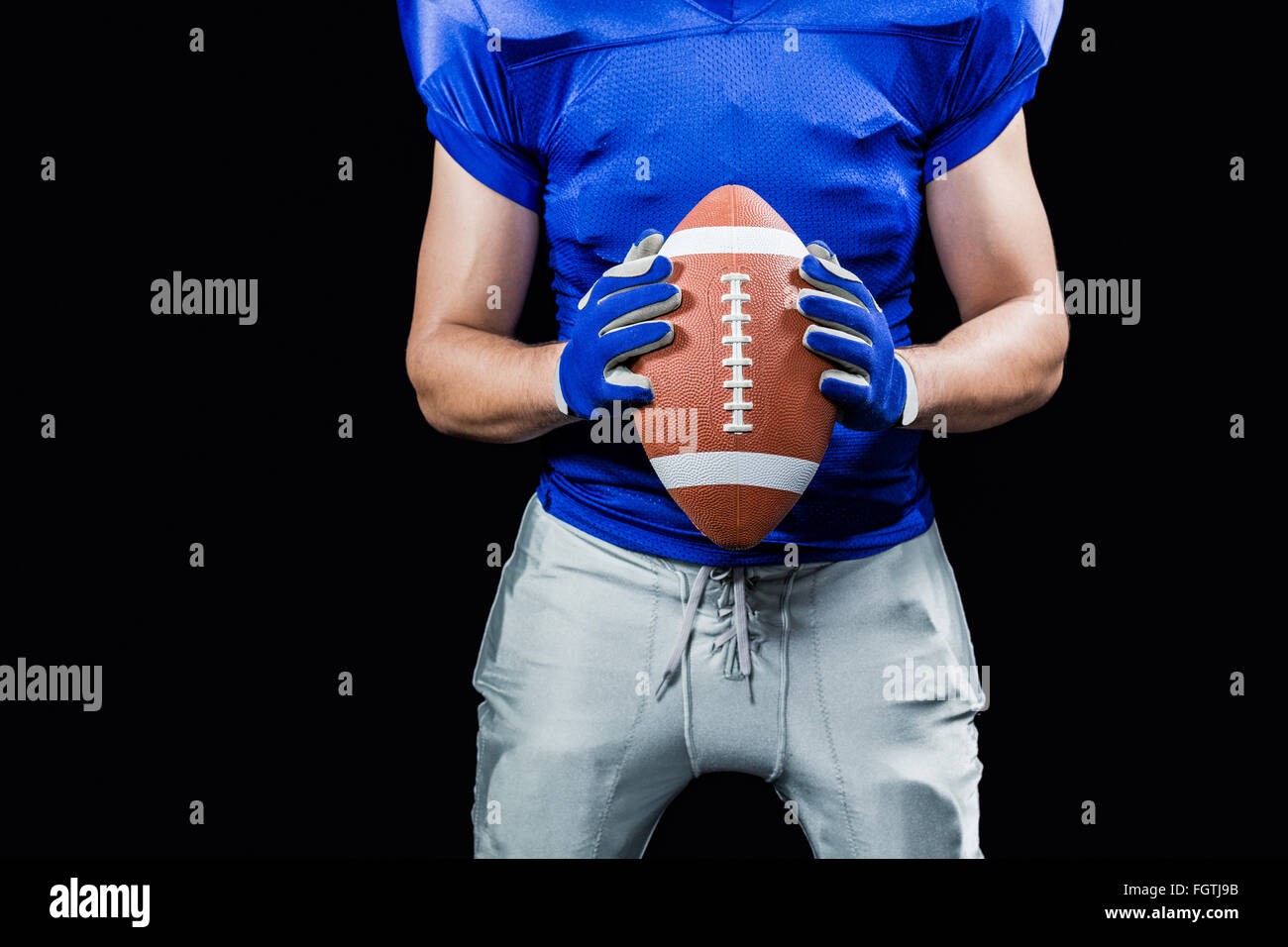American football player holding ball Stock Photo - Alamy