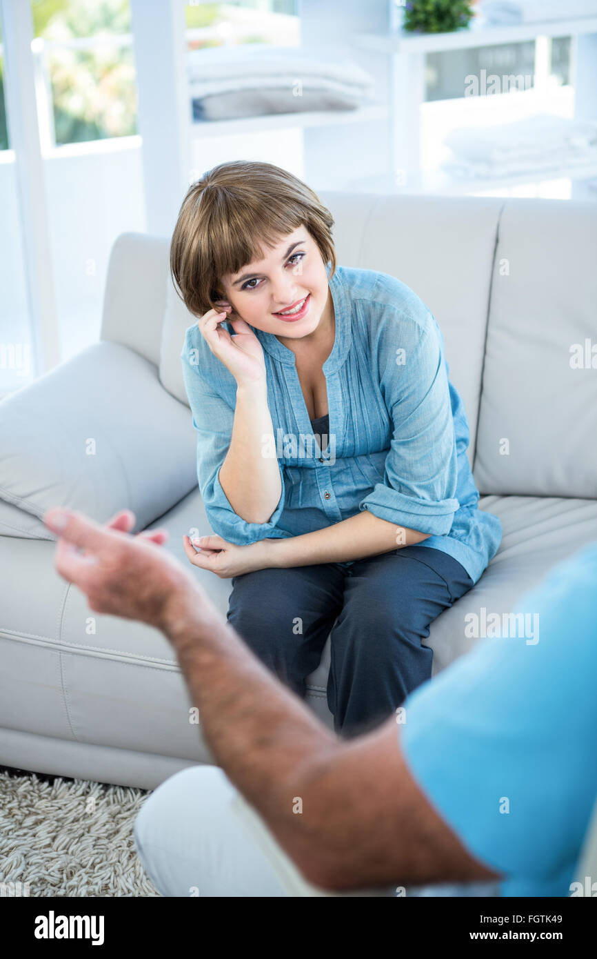 Portrait of smiling beautiful woman sitting on sofa Stock Photo - Alamy
