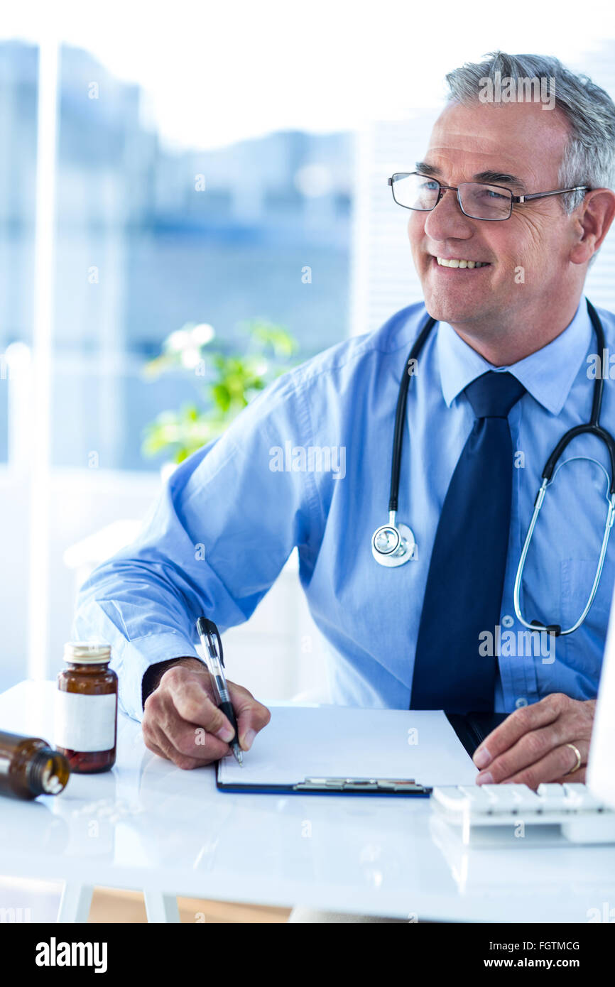 Smiling male doctor looking away in clinic Stock Photo - Alamy