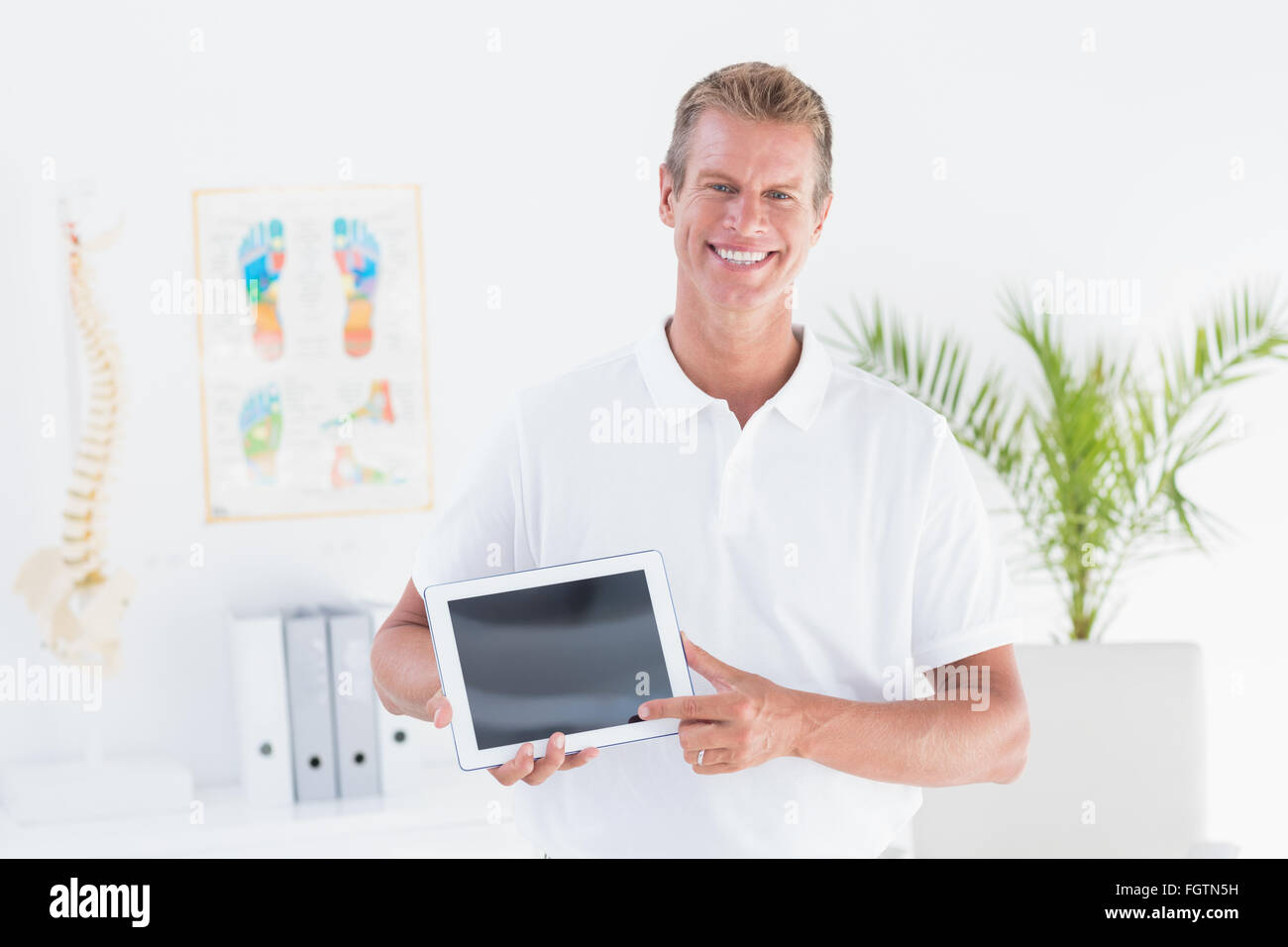Smiling doctor showing laptop pc Stock Photo - Alamy