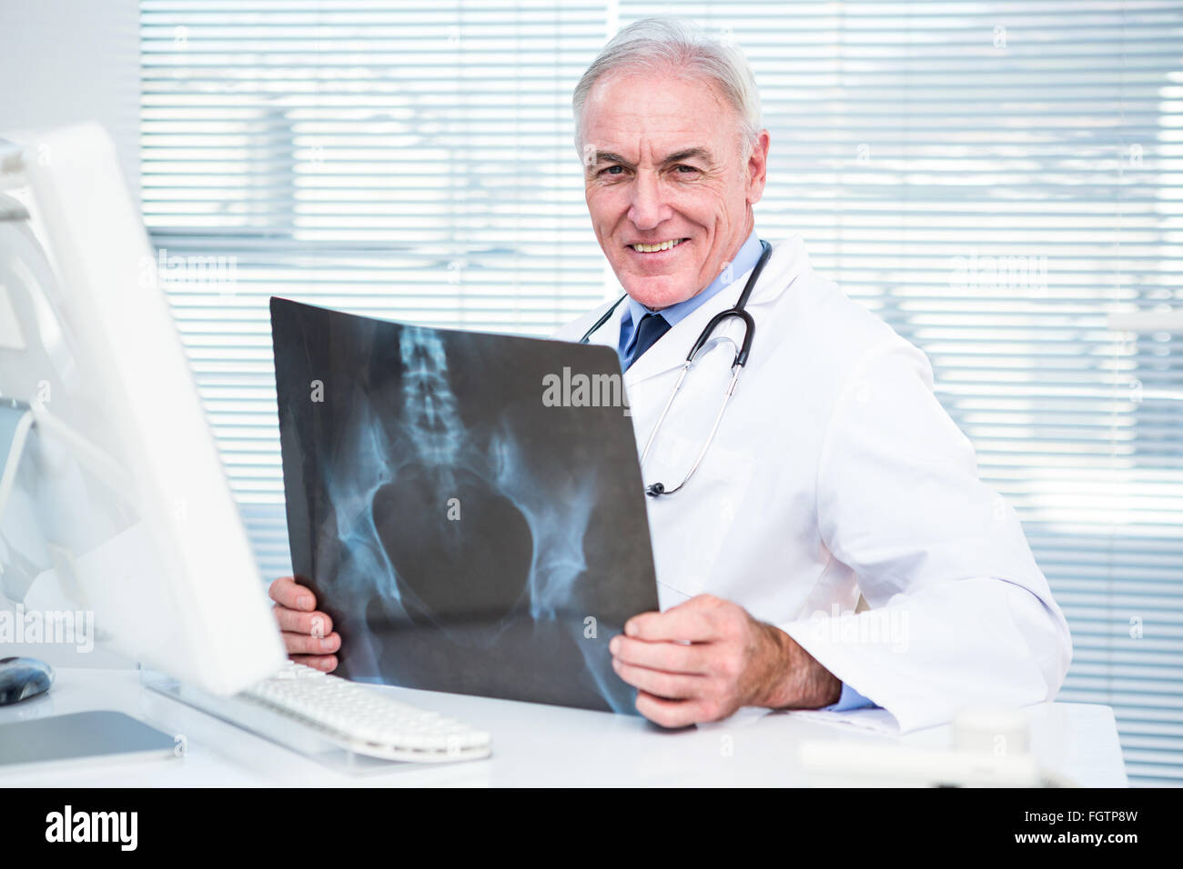 Portrait of doctor with xray sitting in front of computer Stock Photo ...