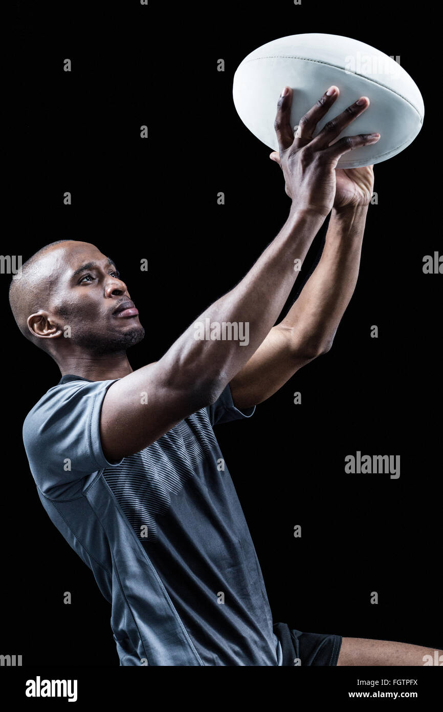 Rugby player looking up while throwing ball Stock Photo - Alamy