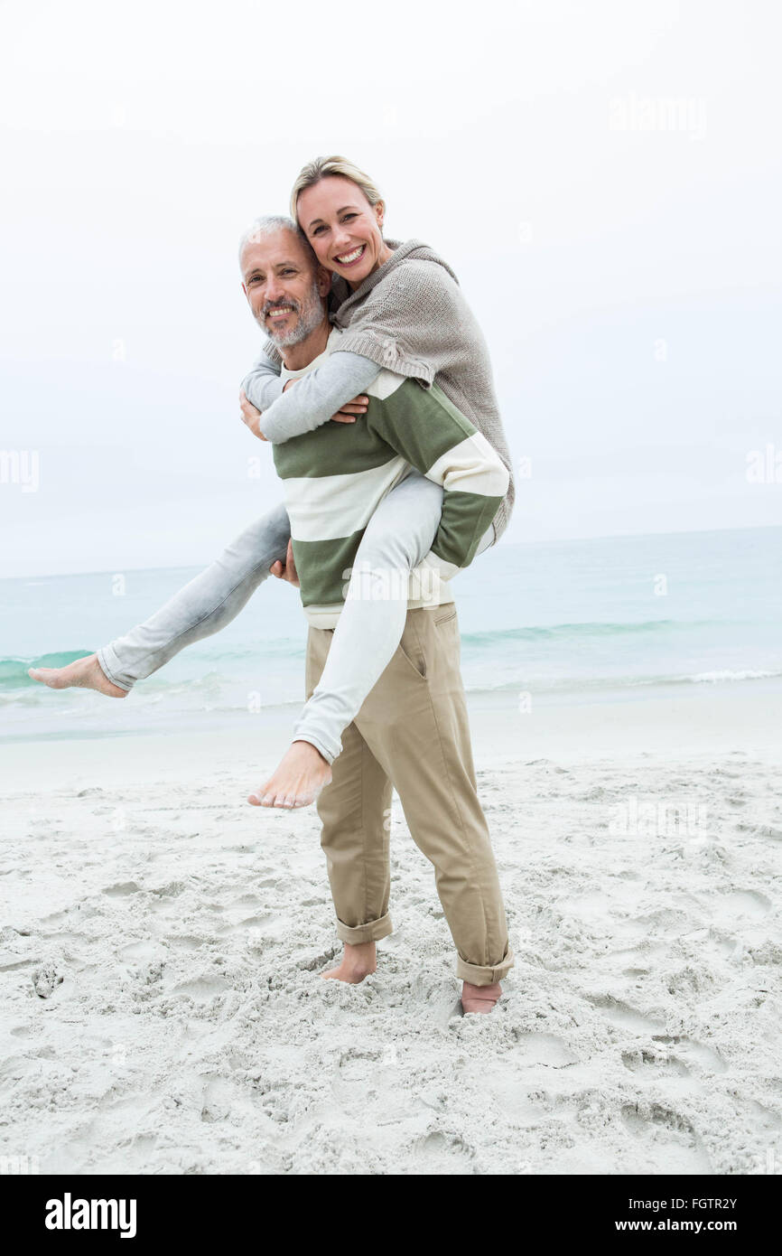 Man giving his partner a piggy back Stock Photo - Alamy
