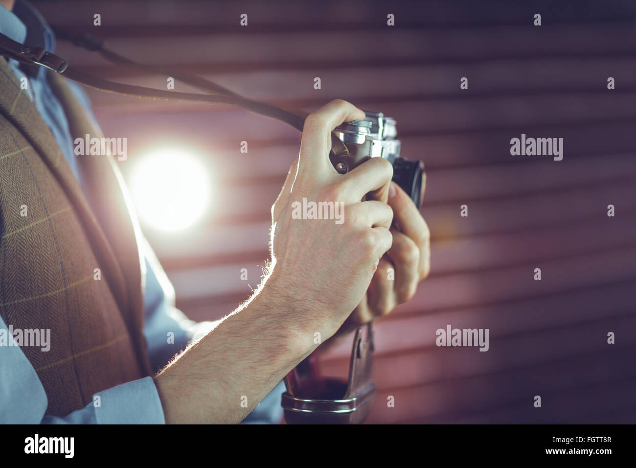 Side view of photogrpaher holding camera Stock Photo - Alamy