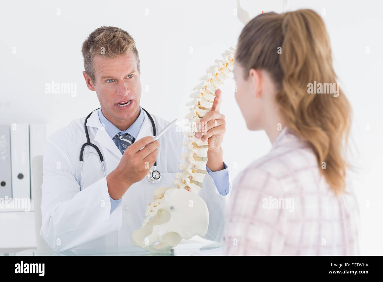 Doctor showing his patient a spine model Stock Photo - Alamy