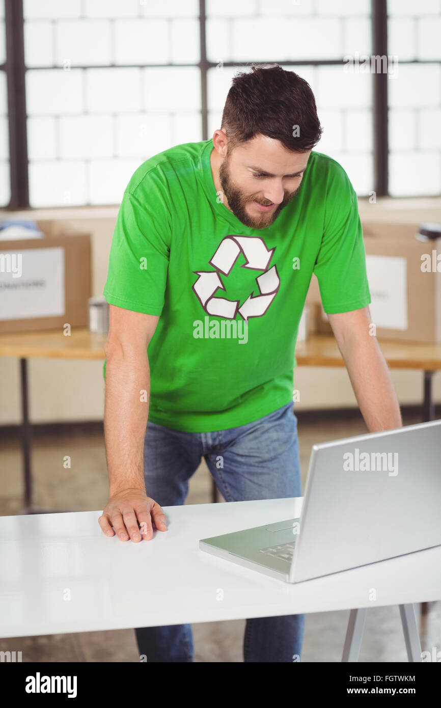 Man in recycling symbol tshirt working on laptop Stock Photo - Alamy