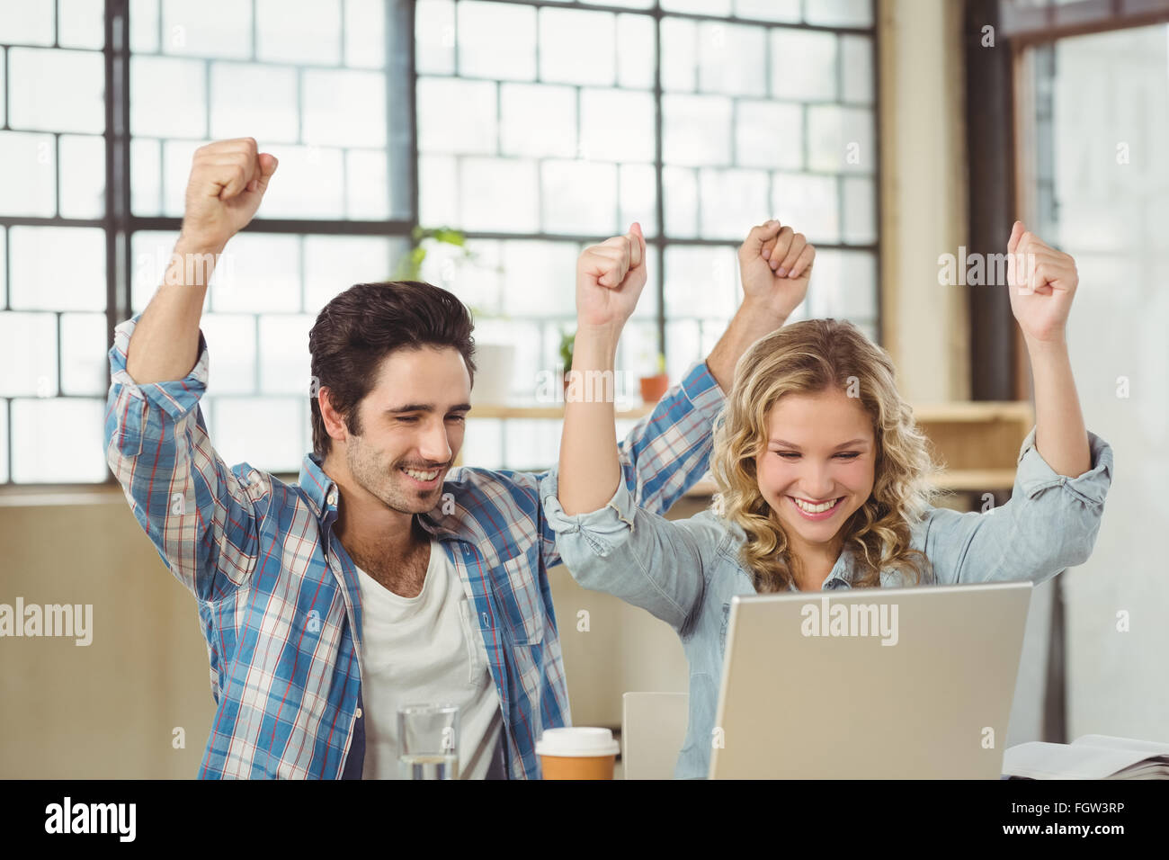 Happy colleagues cheering in office Stock Photo - Alamy