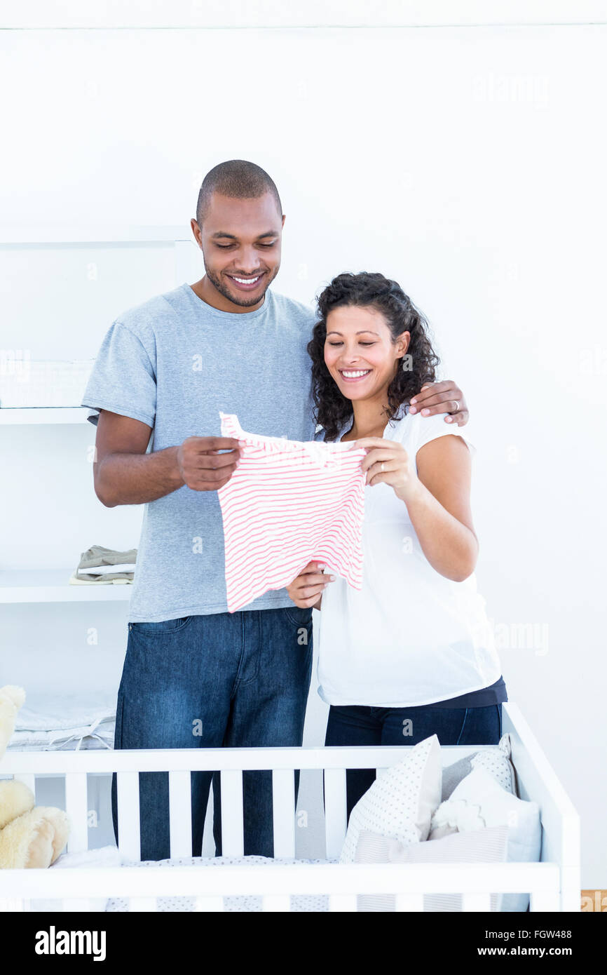 Happy couple standing by crib Stock Photo - Alamy