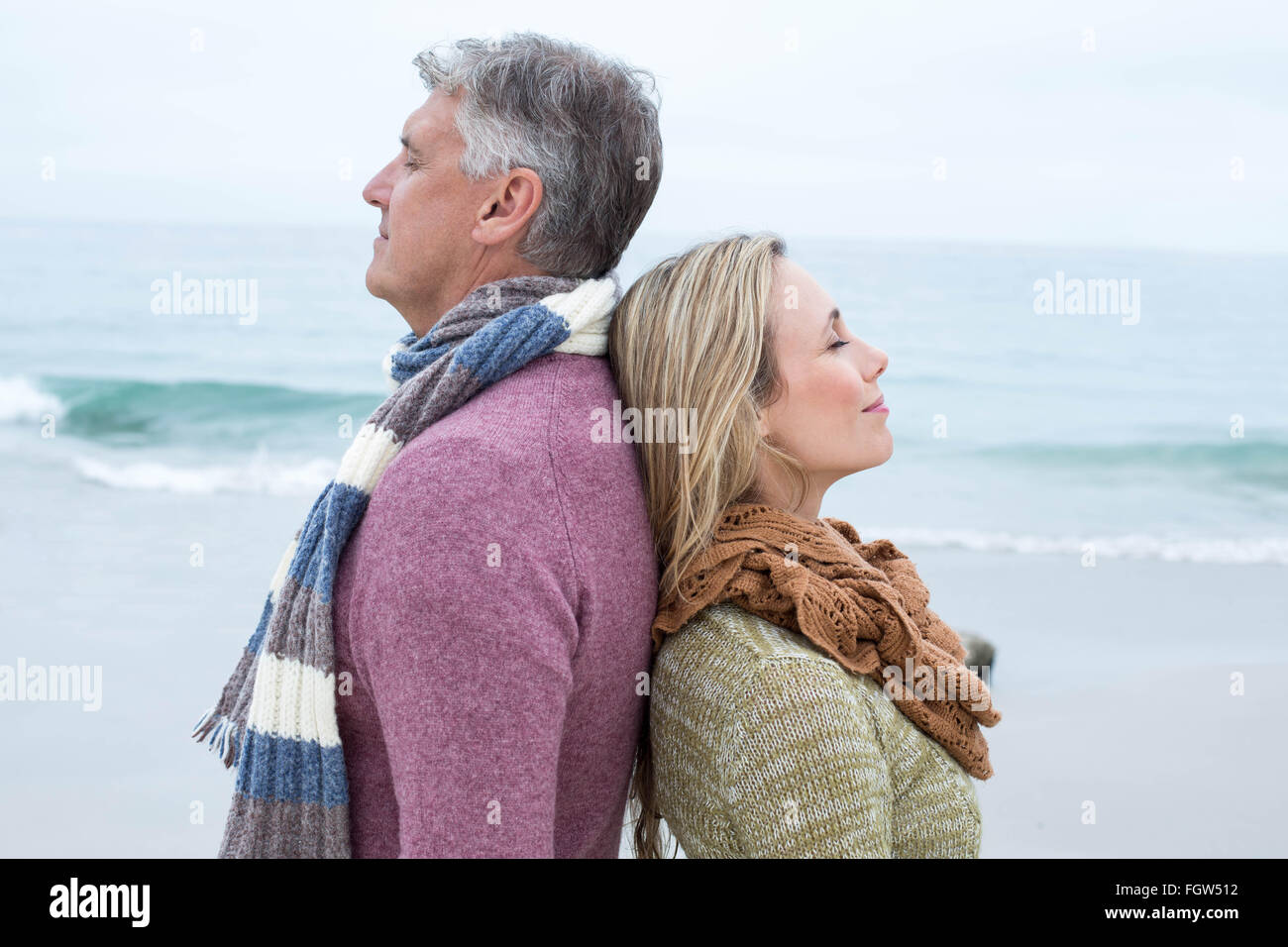 Happy couple standing back to back Stock Photo - Alamy