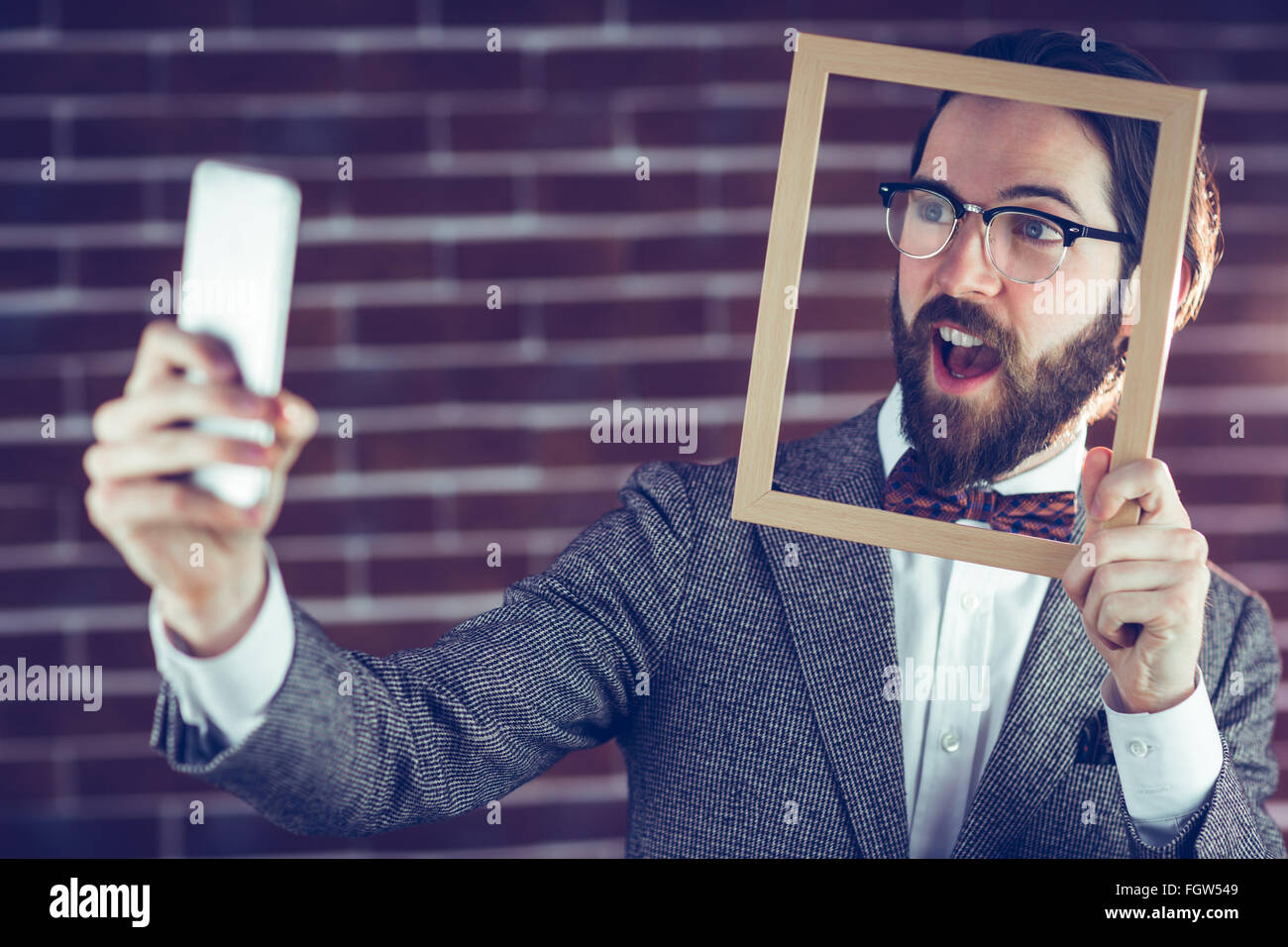 Smart man taking selfie while holding frame Stock Photo - Alamy