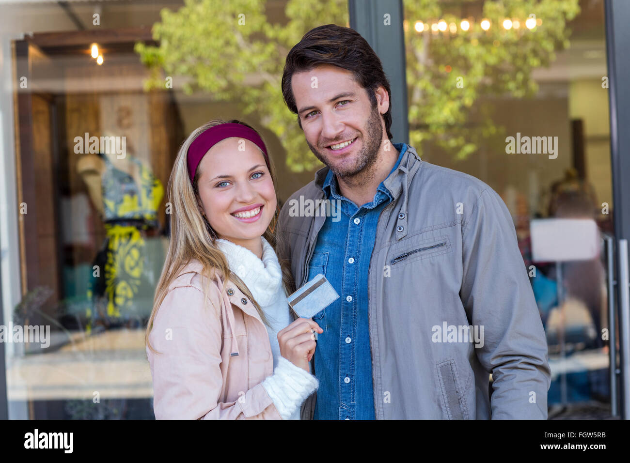 Smiling couple showing credit card Stock Photo - Alamy