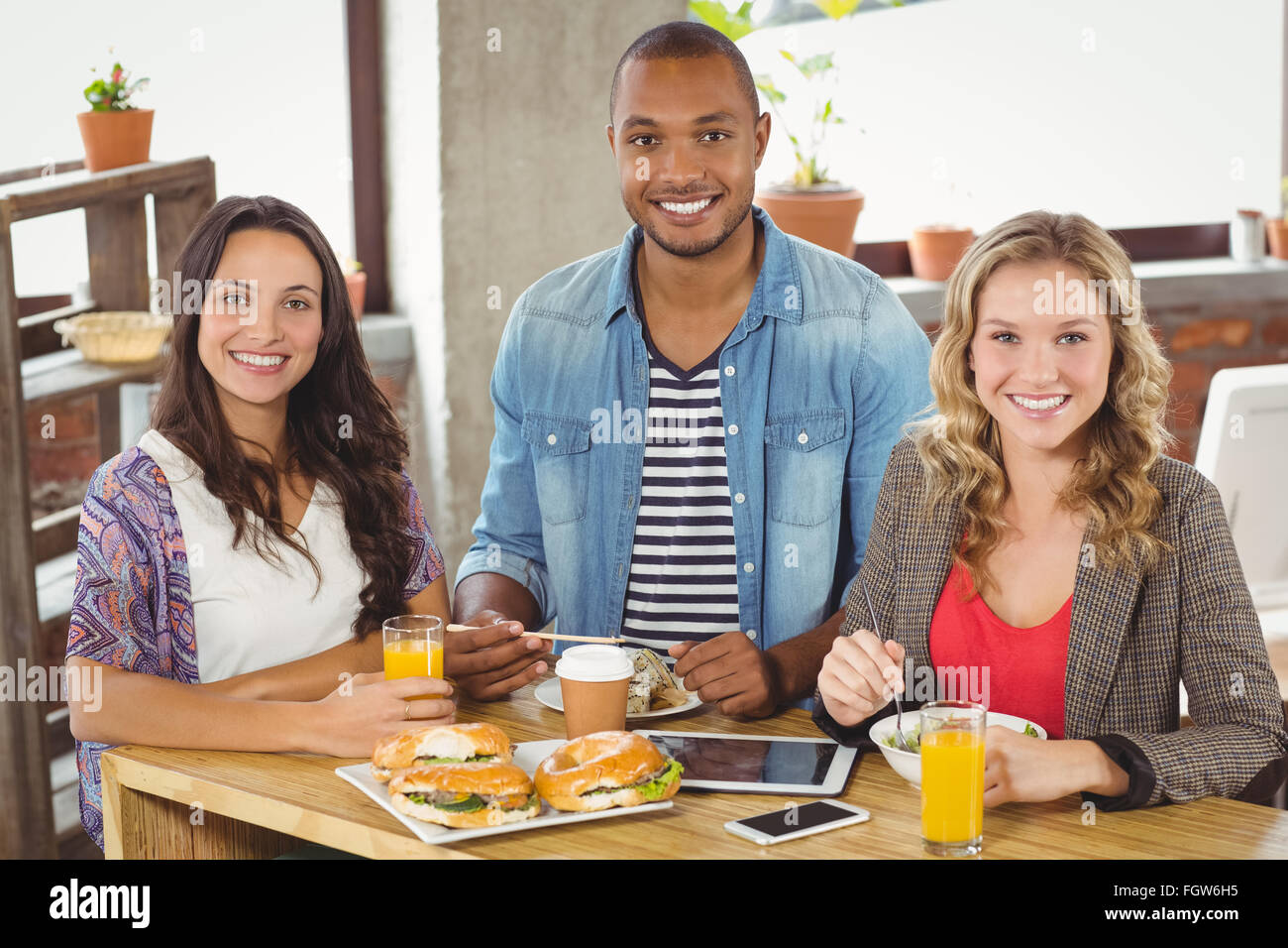 Portrait of smiling colleagues having breakfast in office Stock Photo ...