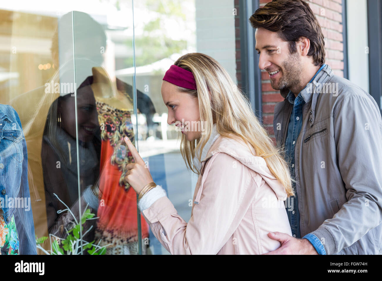 Smiling couple going window shopping and pointing at clothes Stock ...