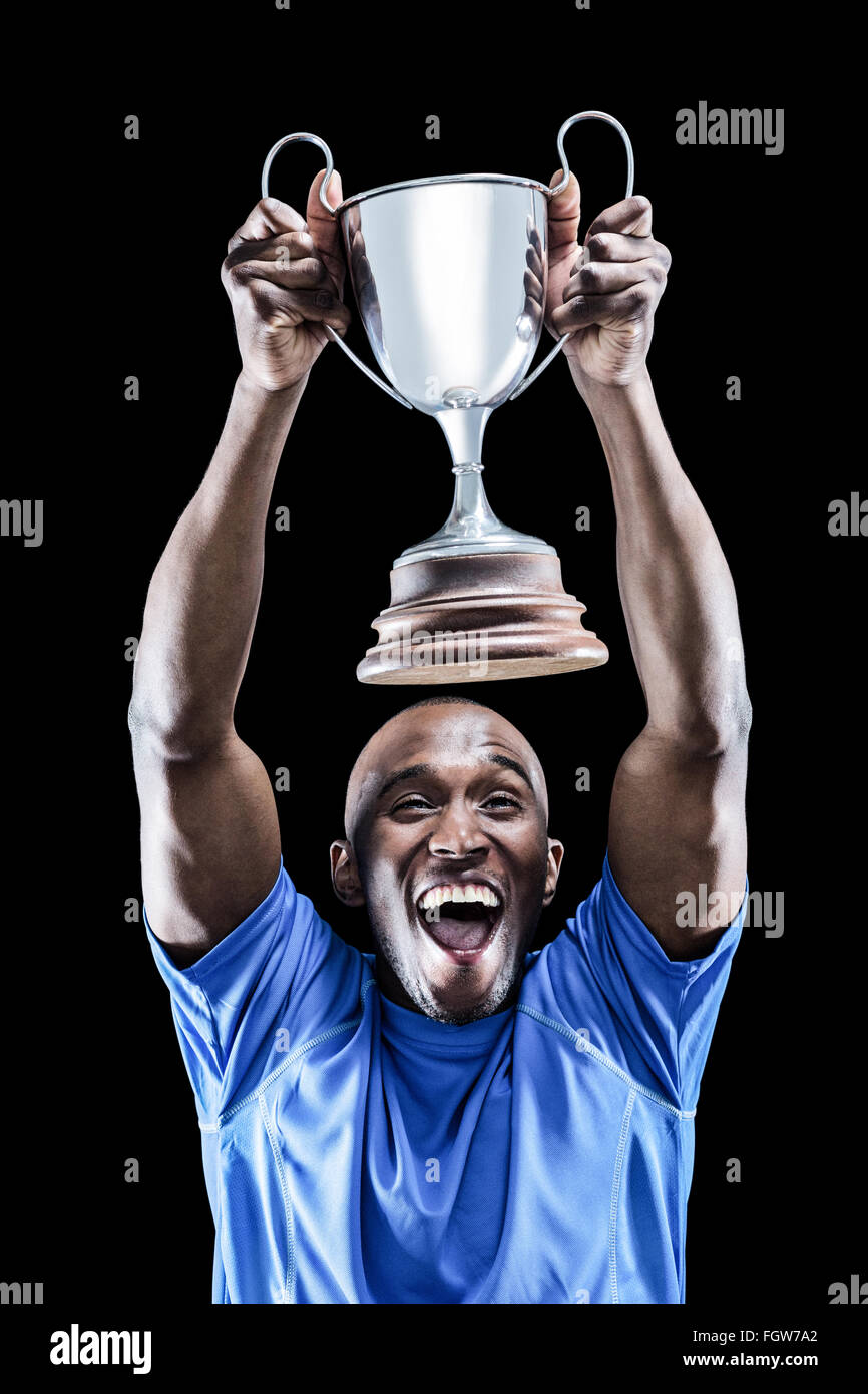 Happy athlete cheering while holding trophy Stock Photo - Alamy