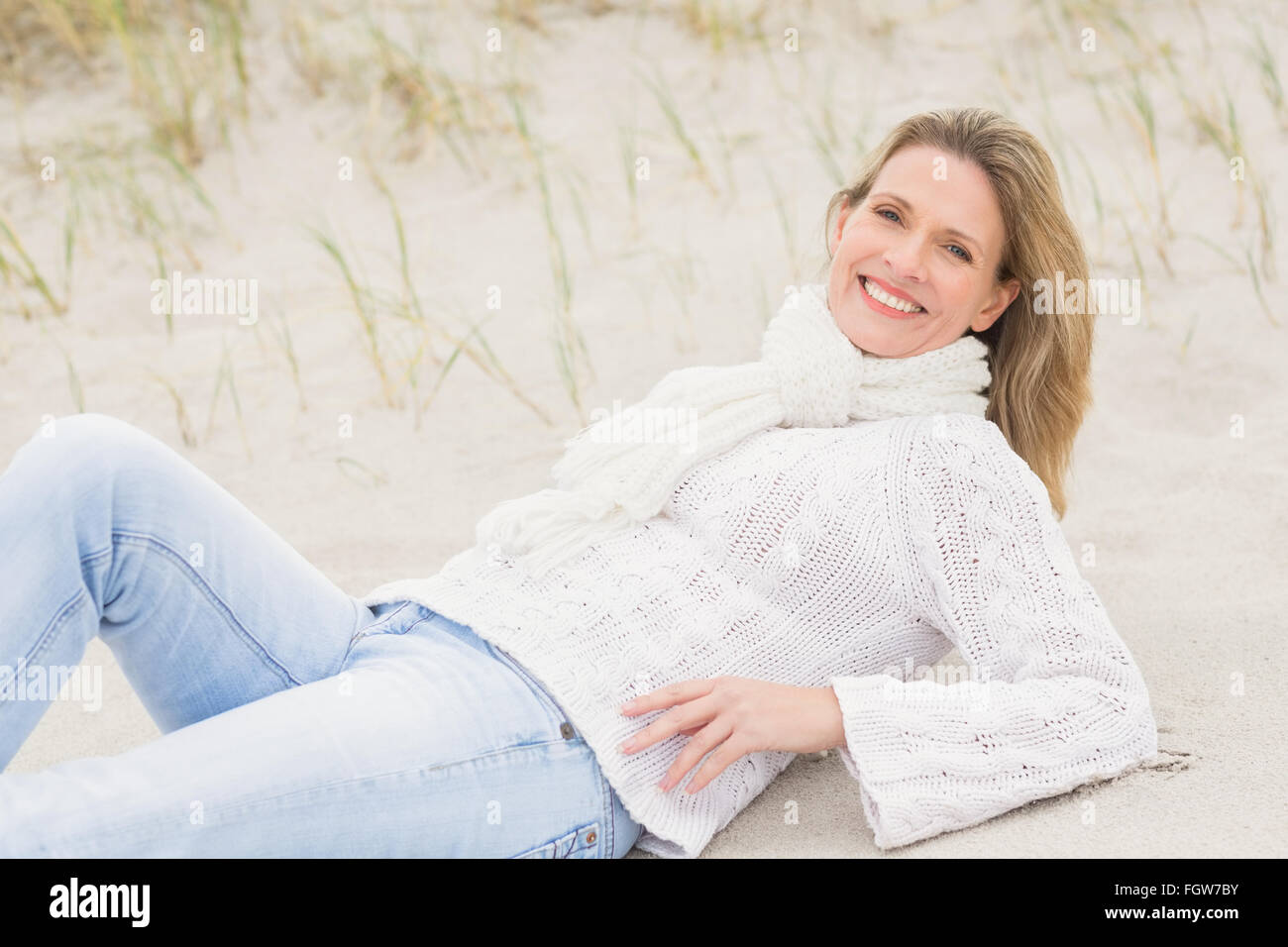Woman lying down on the sand Stock Photo - Alamy