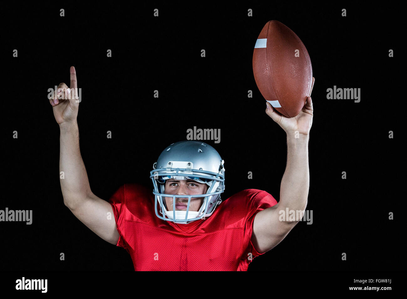 American football player with arms raised holding ball Stock Photo - Alamy