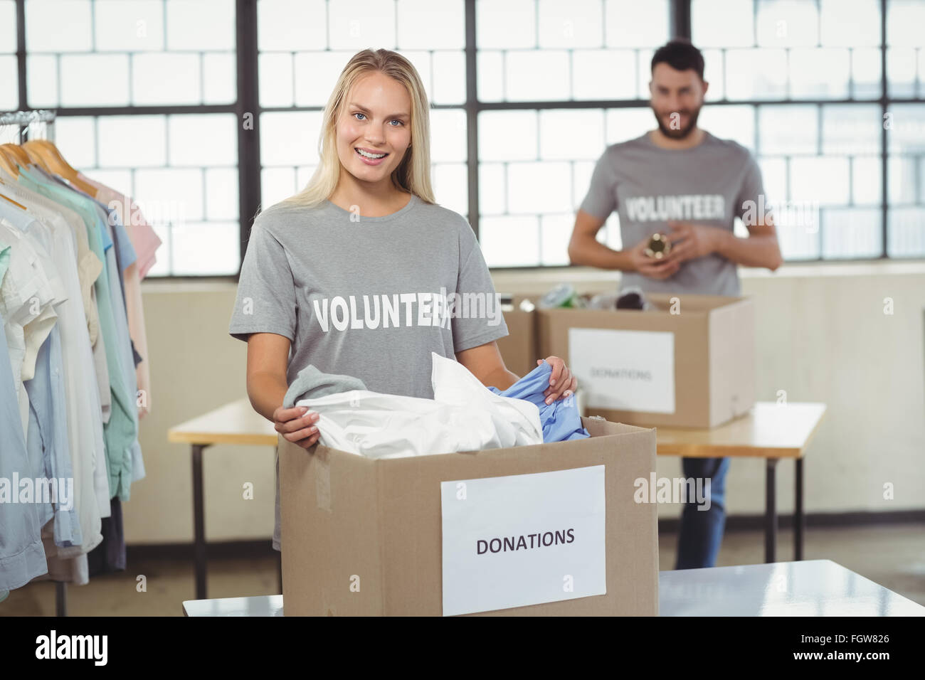 Portrait of woman separating clothes from donation box Stock Photo - Alamy