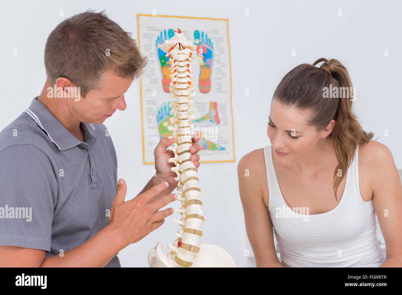 Doctor showing anatomical spine to his patient Stock Photo - Alamy