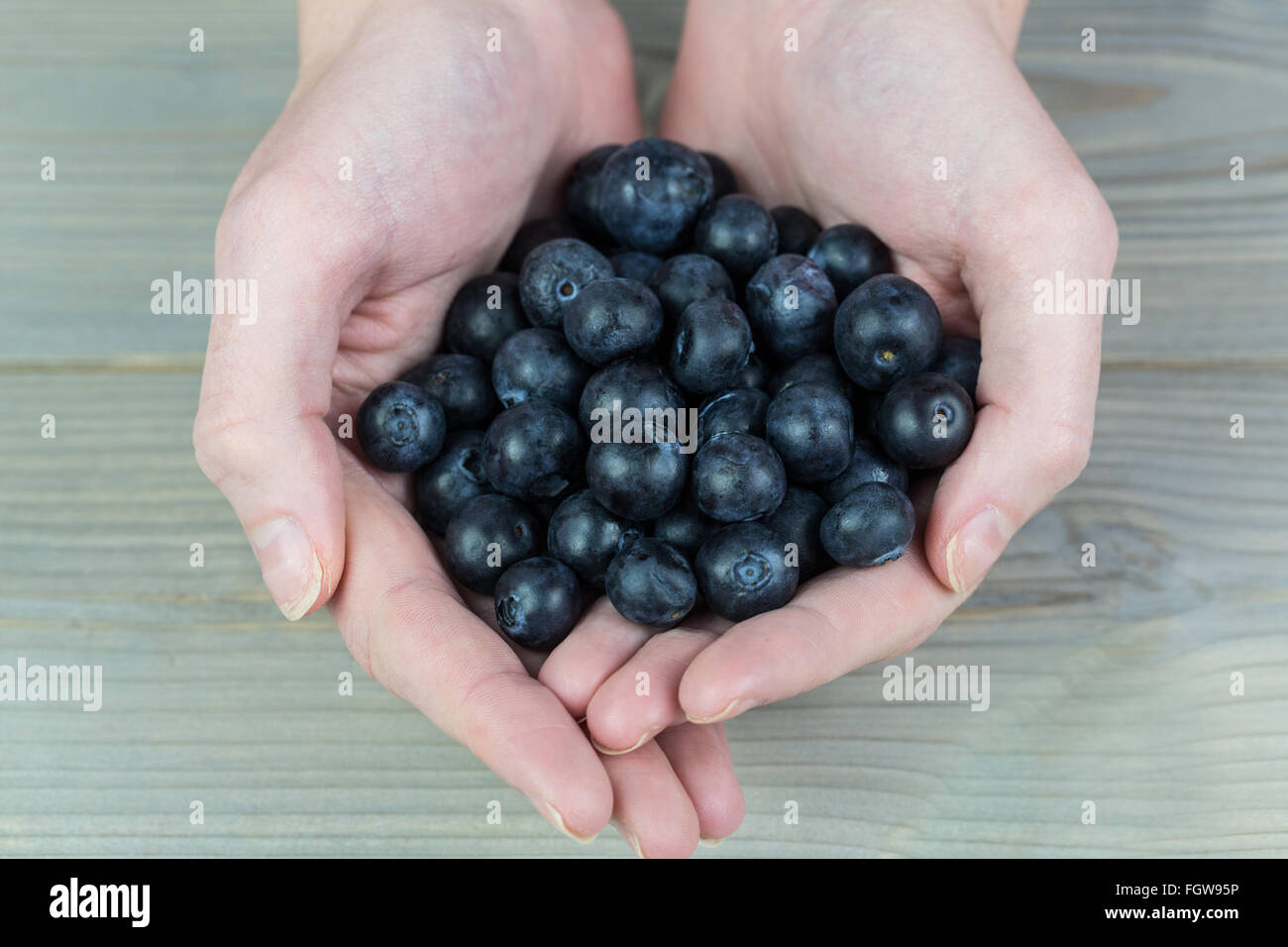 Woman showing handful of blueberries Stock Photo - Alamy