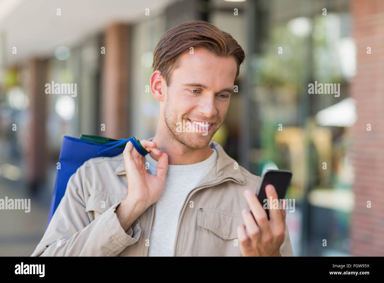 Portrait of a smiling man using his phone Stock Photo - Alamy