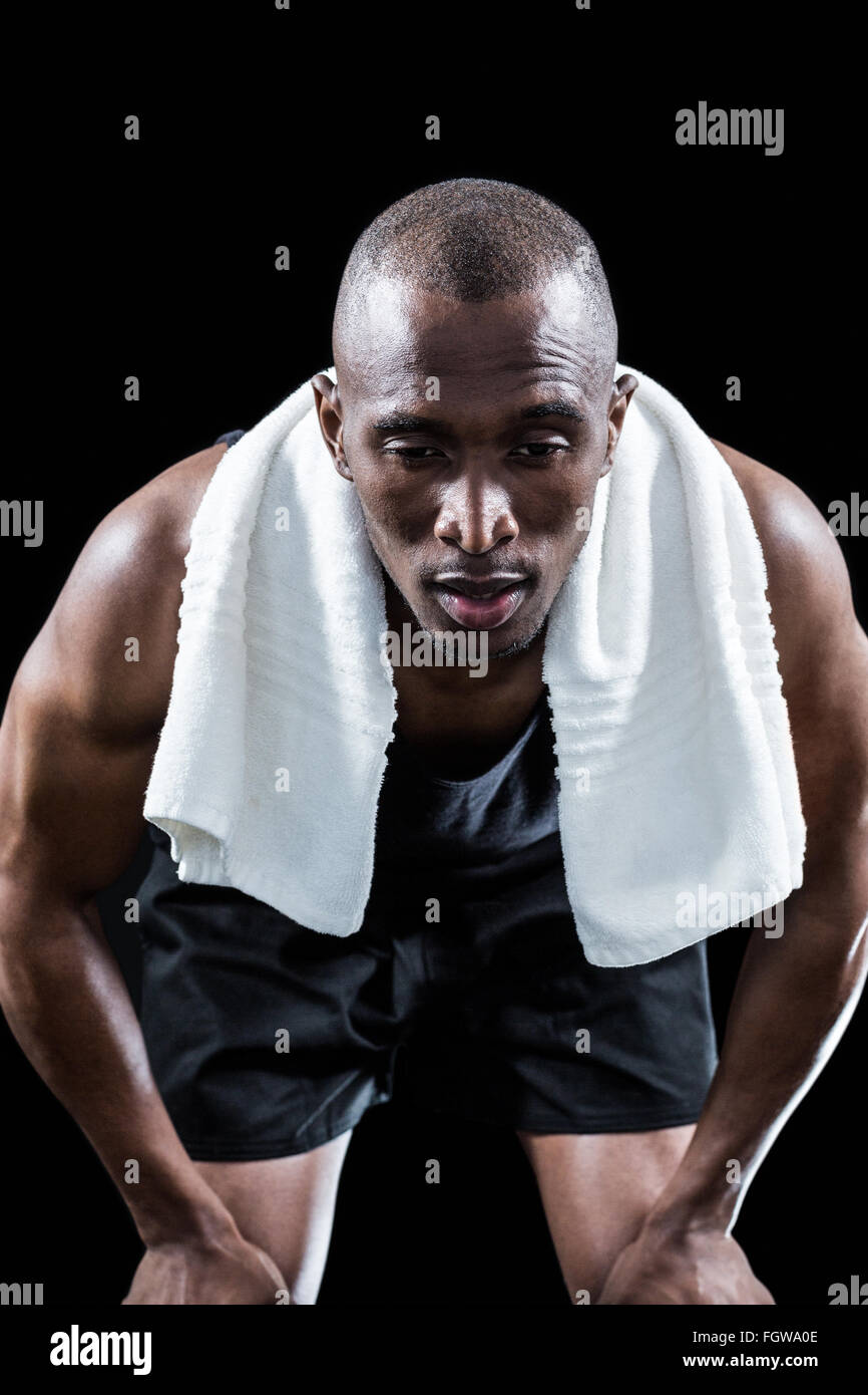 Muscular man resting while keeping hand on knee Stock Photo - Alamy