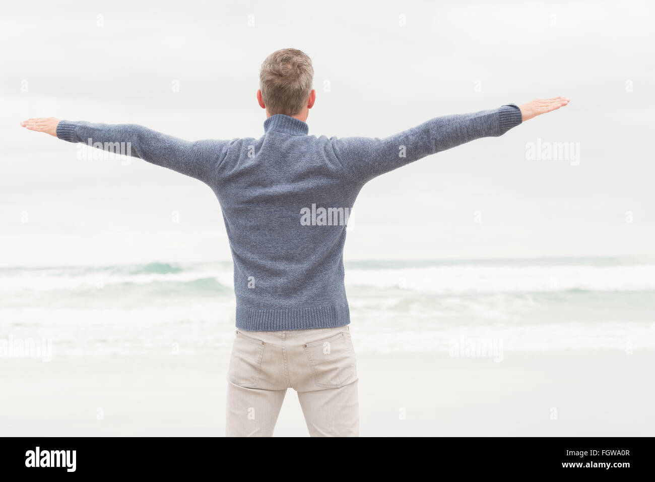 Man standing with arms out wide Stock Photo - Alamy