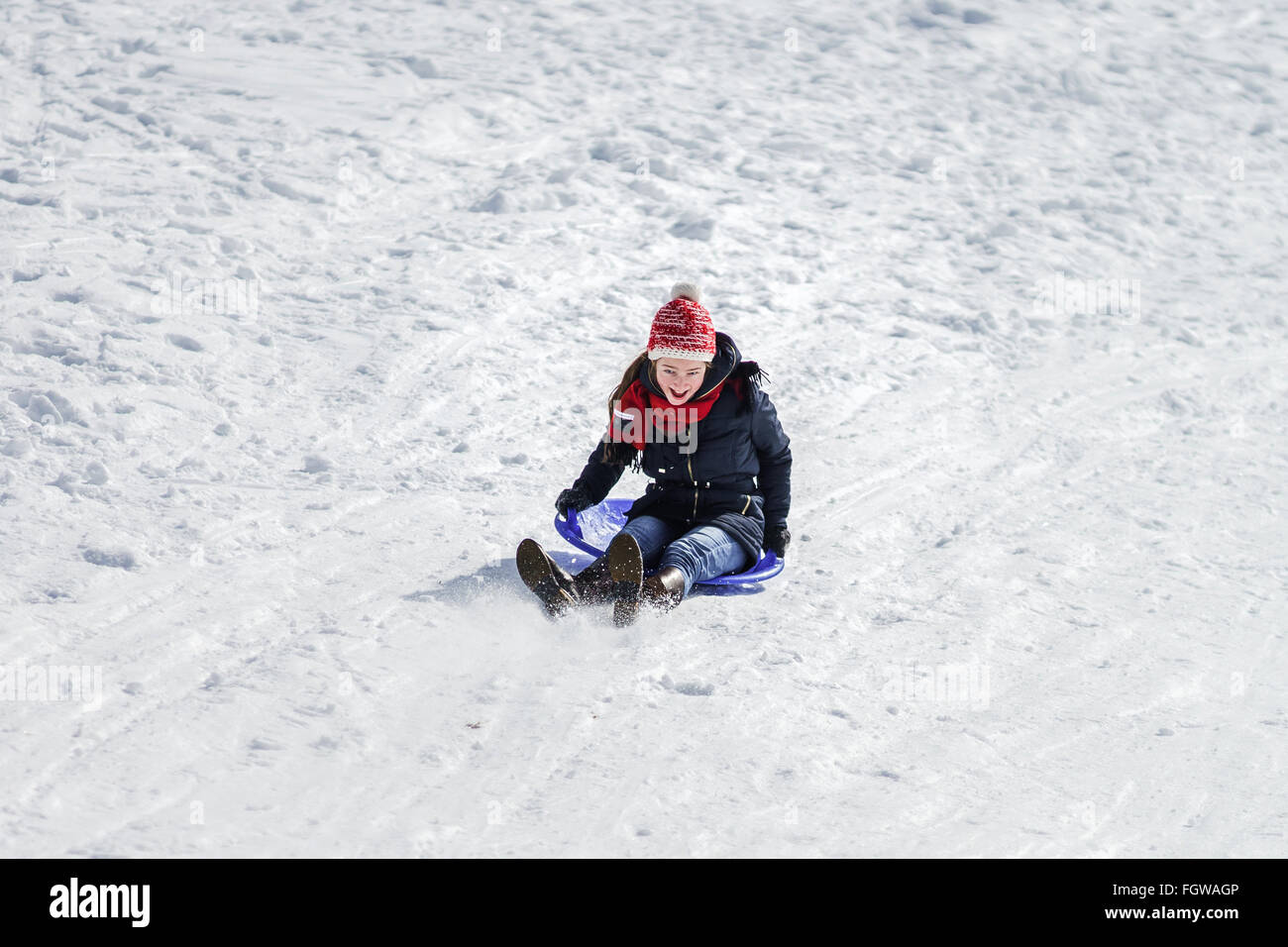 Teenage girl sledding from the hill, snowy weather Stock Photo - Alamy