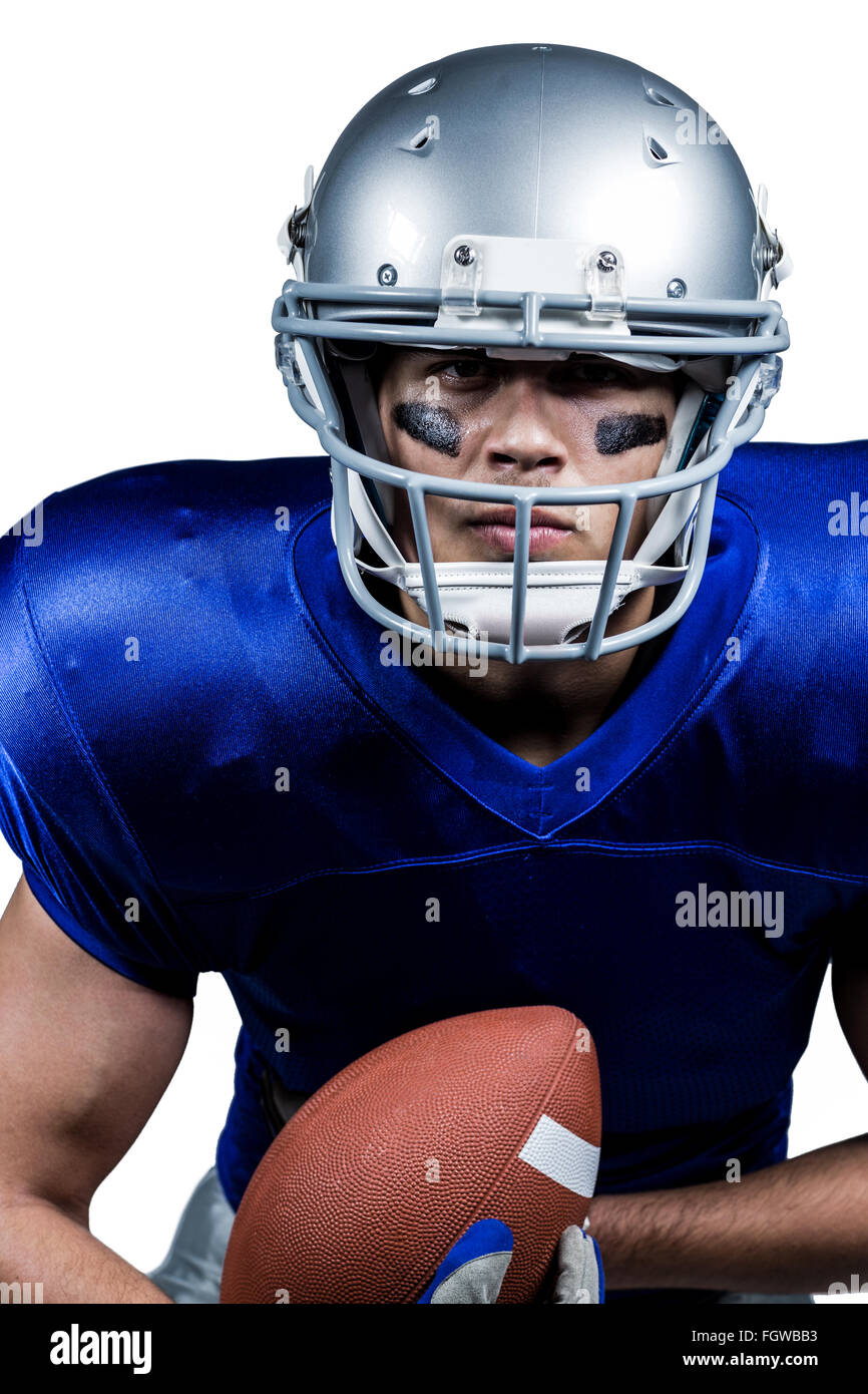 Determined American football player in uniform holding ball Stock Photo ...