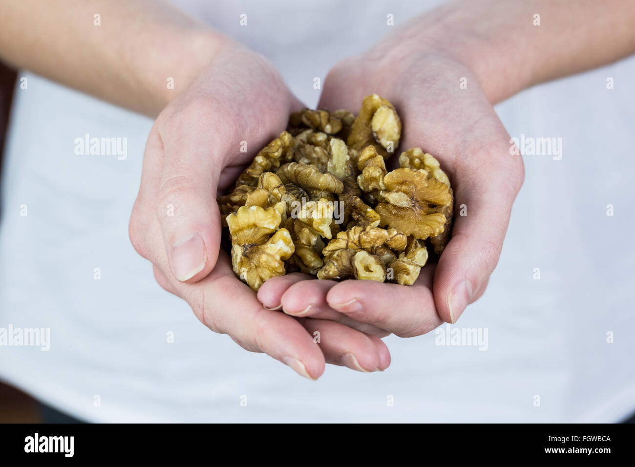 Woman showing handful of walnuts Stock Photo - Alamy