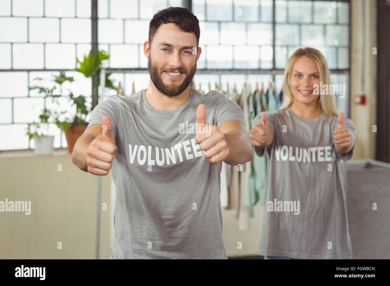 Happy smiling volunteers giving thumbs Stock Photo - Alamy