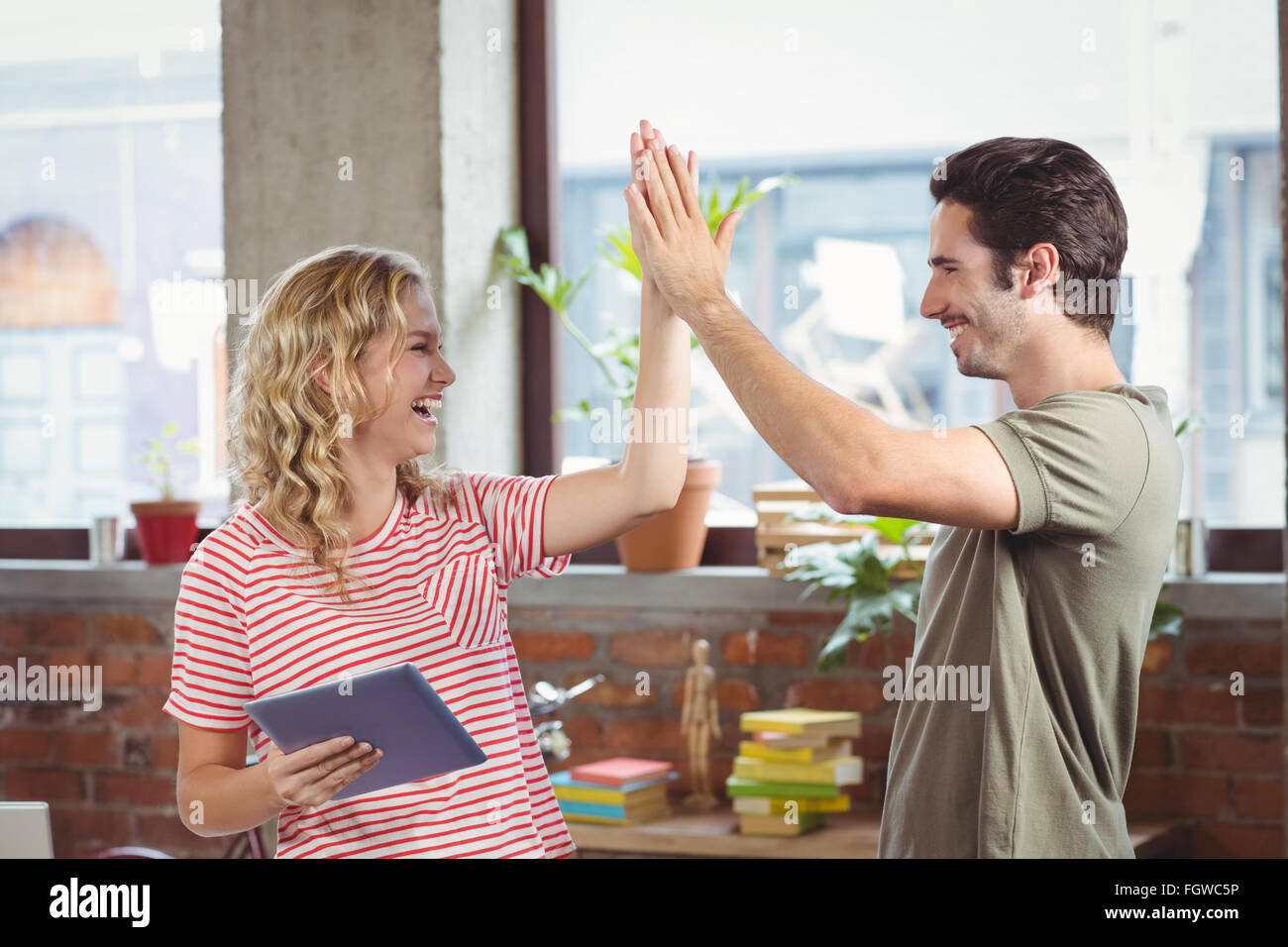 High five done by colleague in office Stock Photo - Alamy