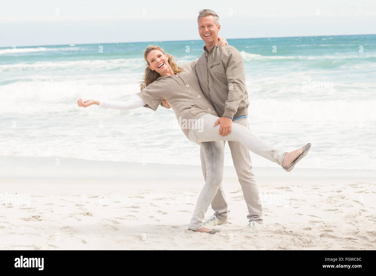 Smiling man holding his partner Stock Photo - Alamy