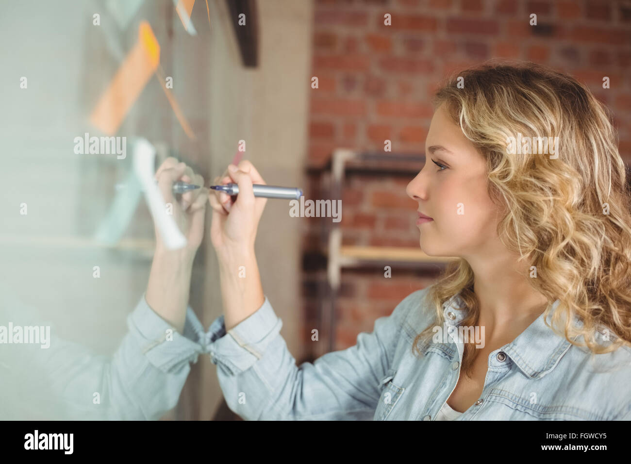 Creative beautiful businesswoman writing on board in office Stock Photo ...