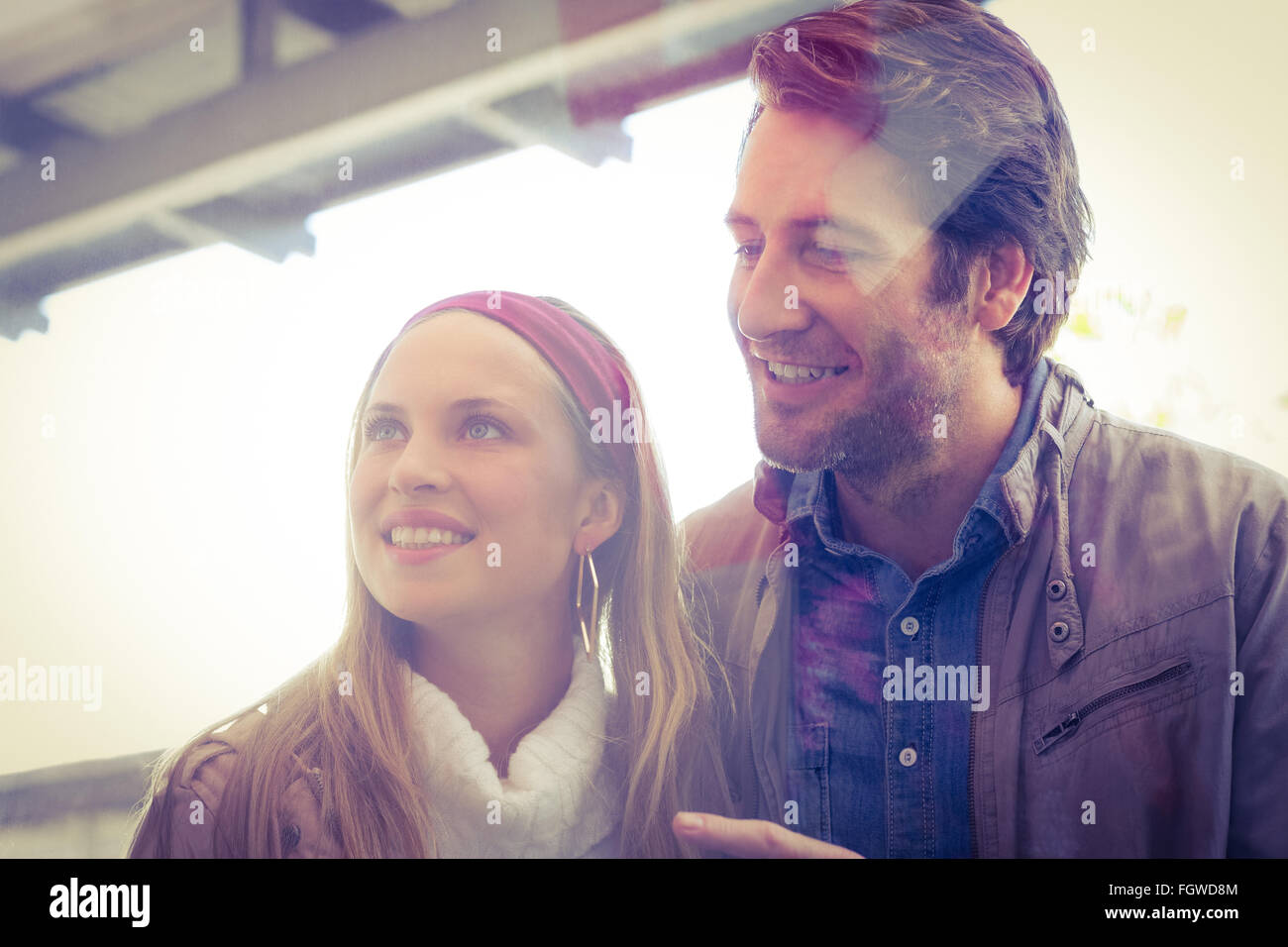Smiling couple looking and pointing at window Stock Photo - Alamy