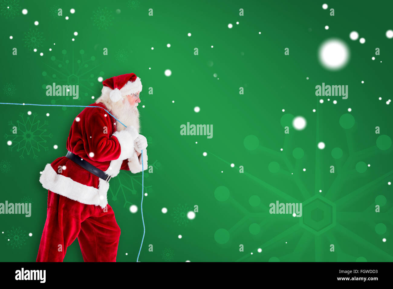 Composite image of santa claus pulling rope Stock Photo - Alamy