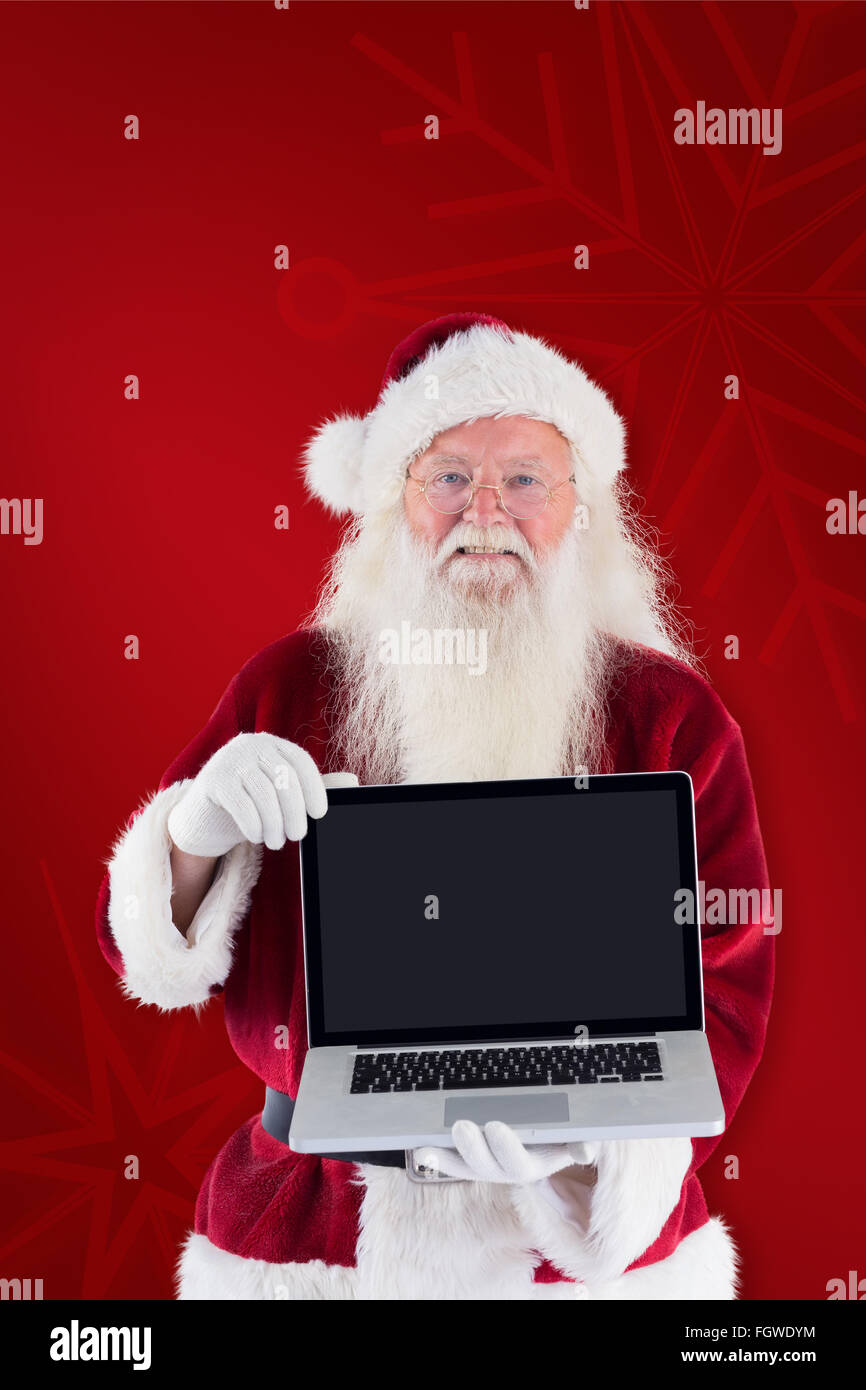 Composite image of santa claus presents a laptop Stock Photo - Alamy