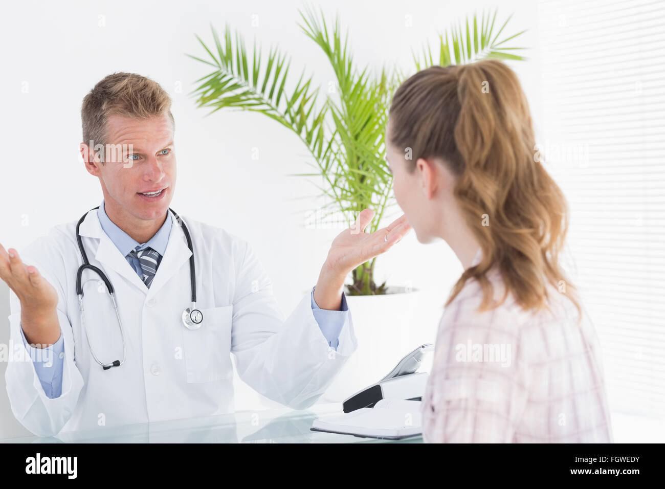 Happy doctor talking to patient Stock Photo - Alamy