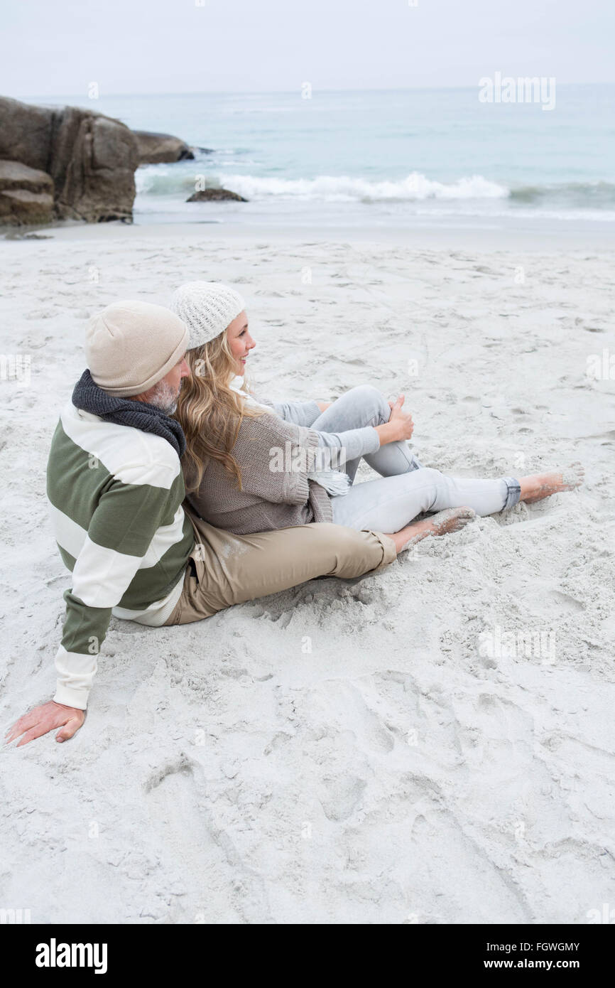 Cute couple sitting in the sand Stock Photo - Alamy