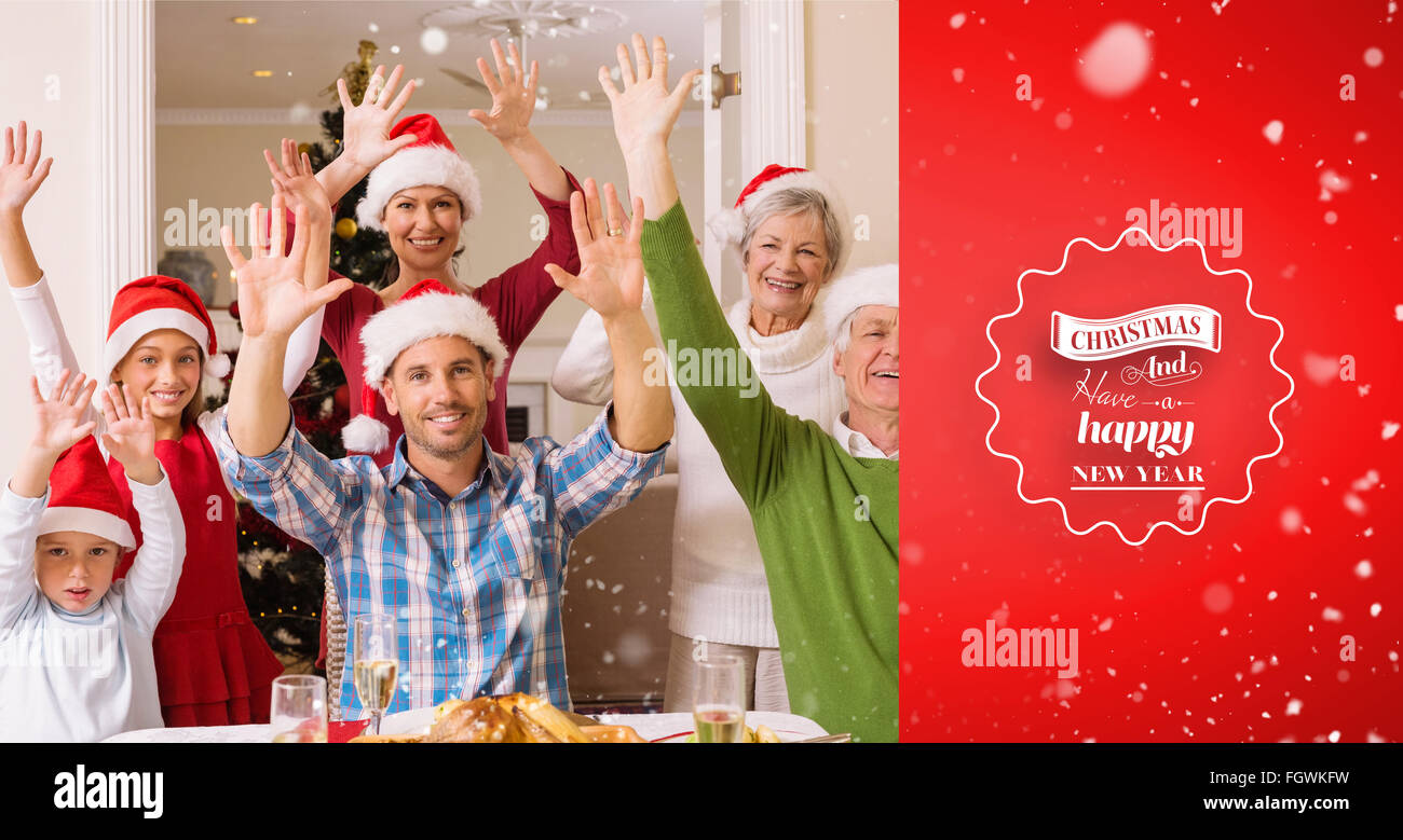 Composite image of happy extended family in santa hat cheering at ...