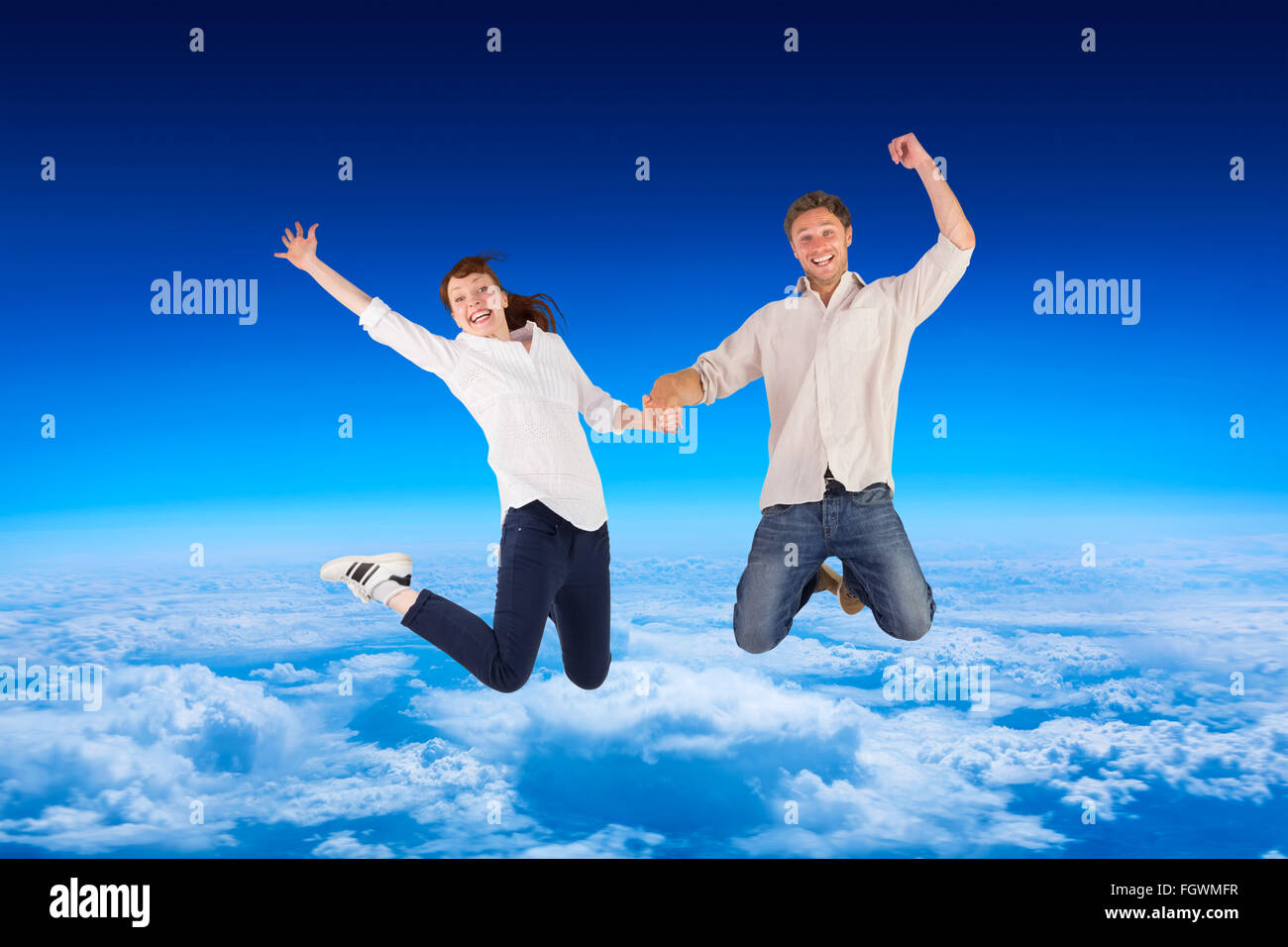 Composite image of couple jumping and holding hands Stock Photo - Alamy