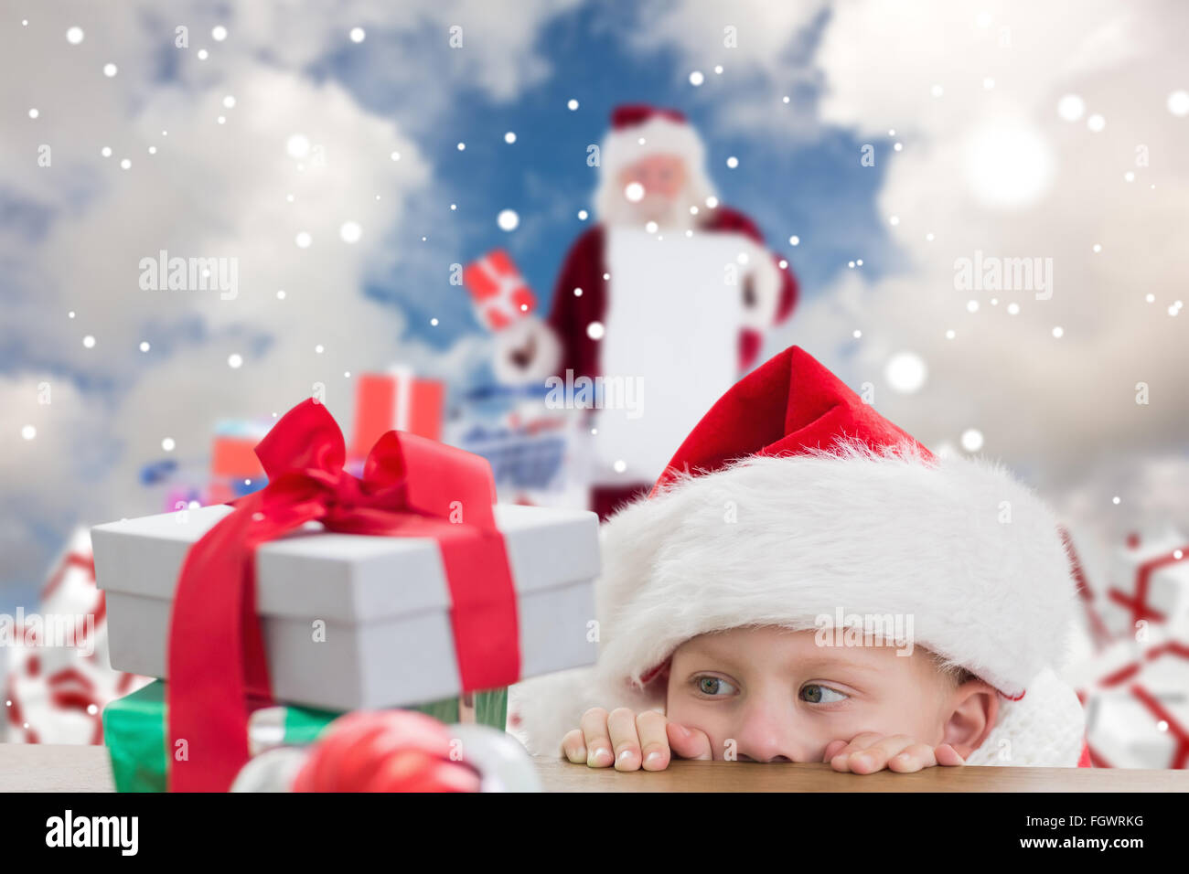 Composite image of cute boy looking at gifts Stock Photo - Alamy