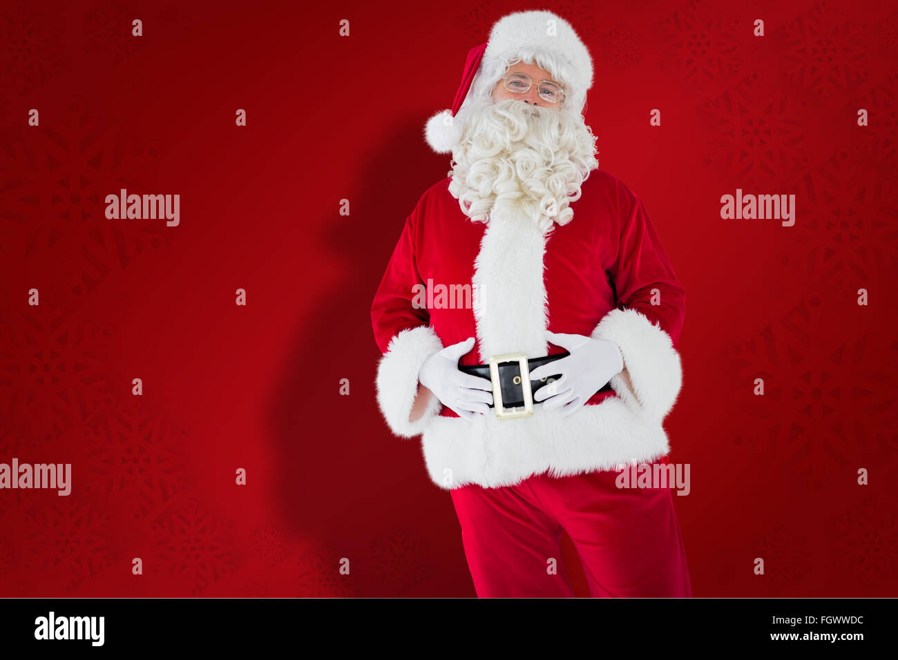 Composite image of santa claus holding his belly Stock Photo - Alamy