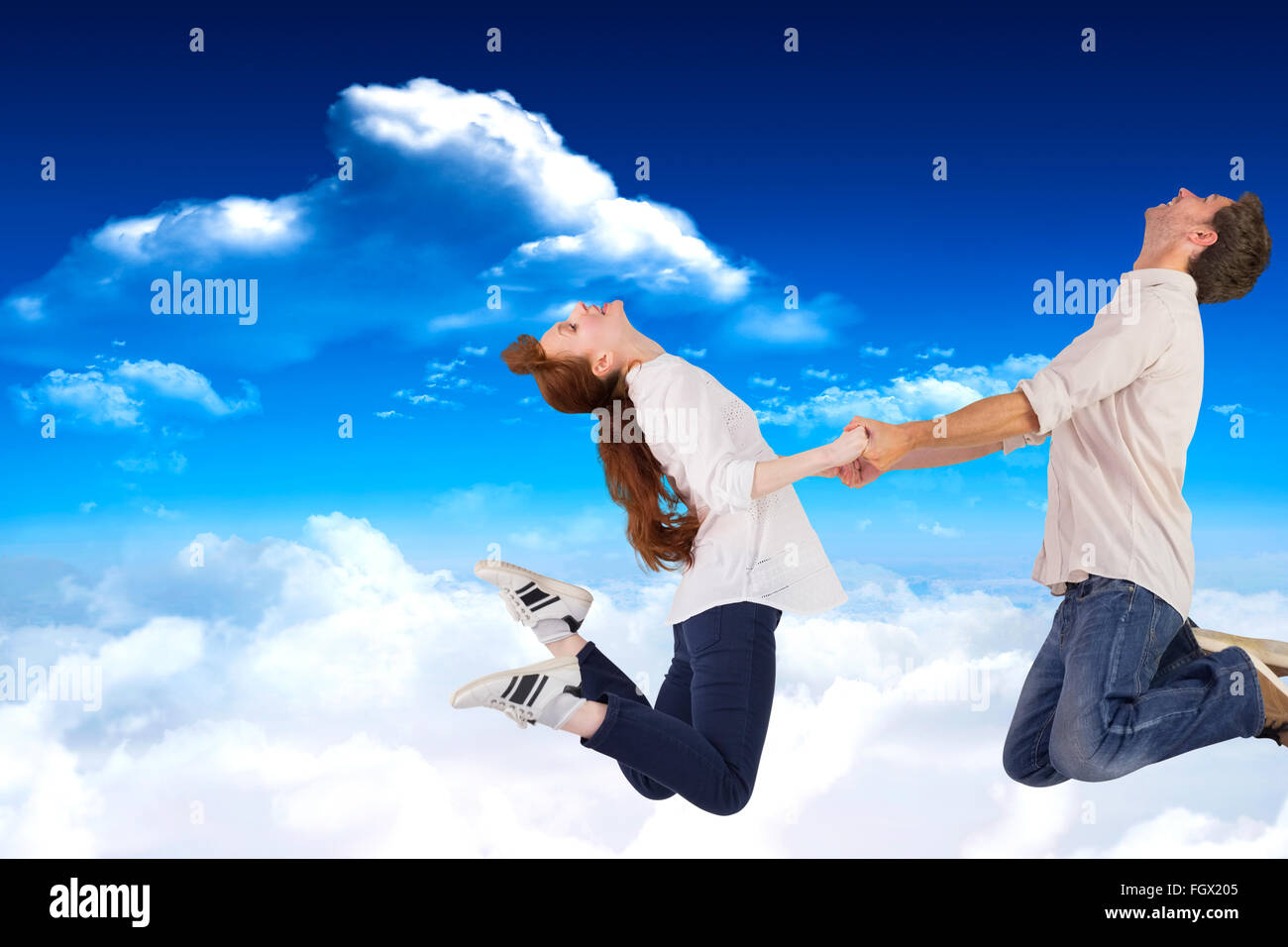Composite image of couple jumping and holding hands Stock Photo - Alamy