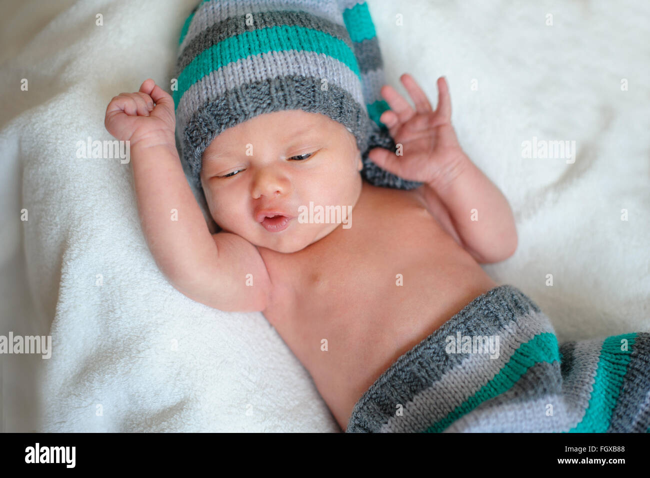 little baby boy in a knitted hat lying on the bed Stock Photo - Alamy