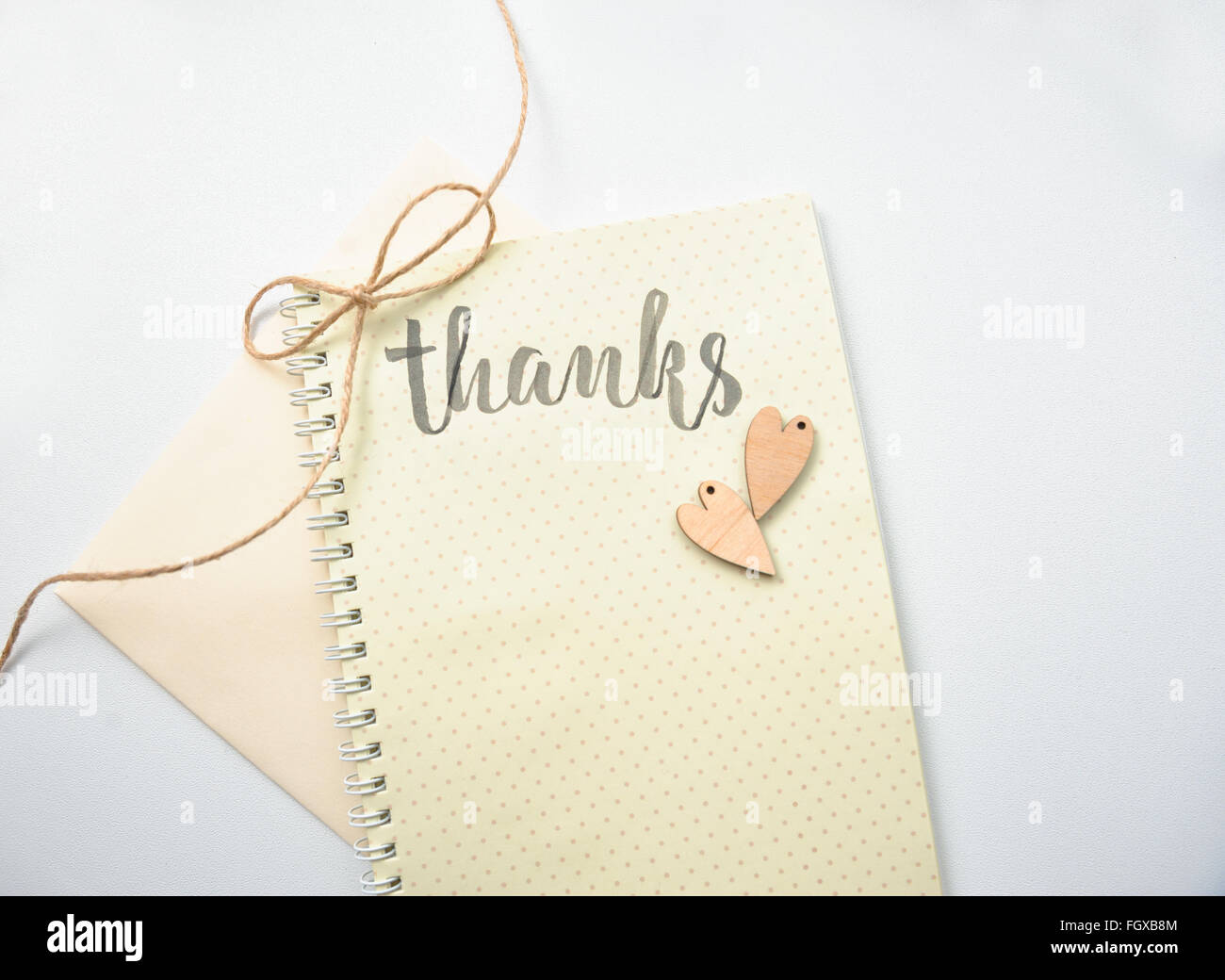 Postcard with the words thanks on a paper background with two hearts ...
